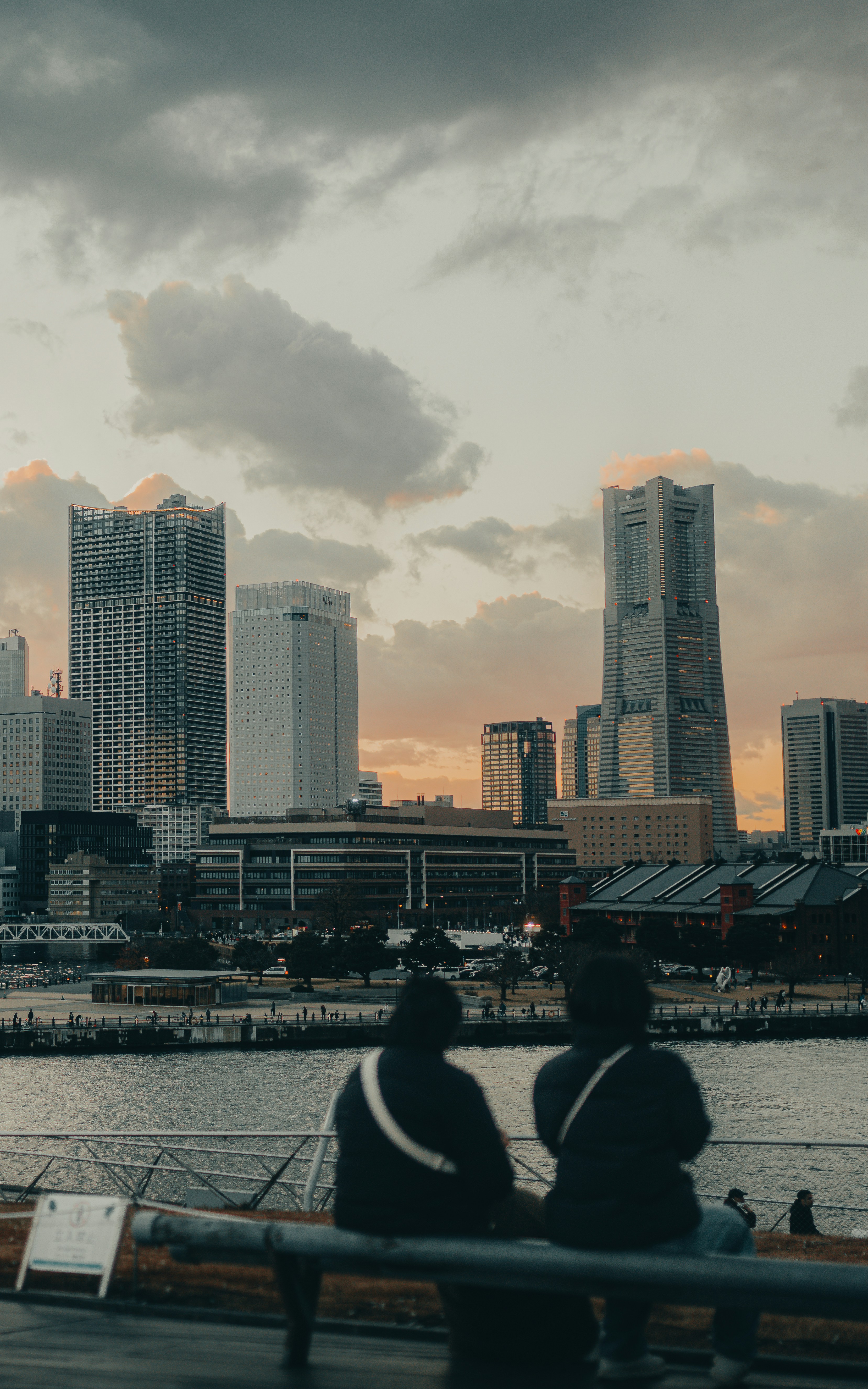 Ig @sir.simo | Two people sit on a bench overlooking a city skyline.