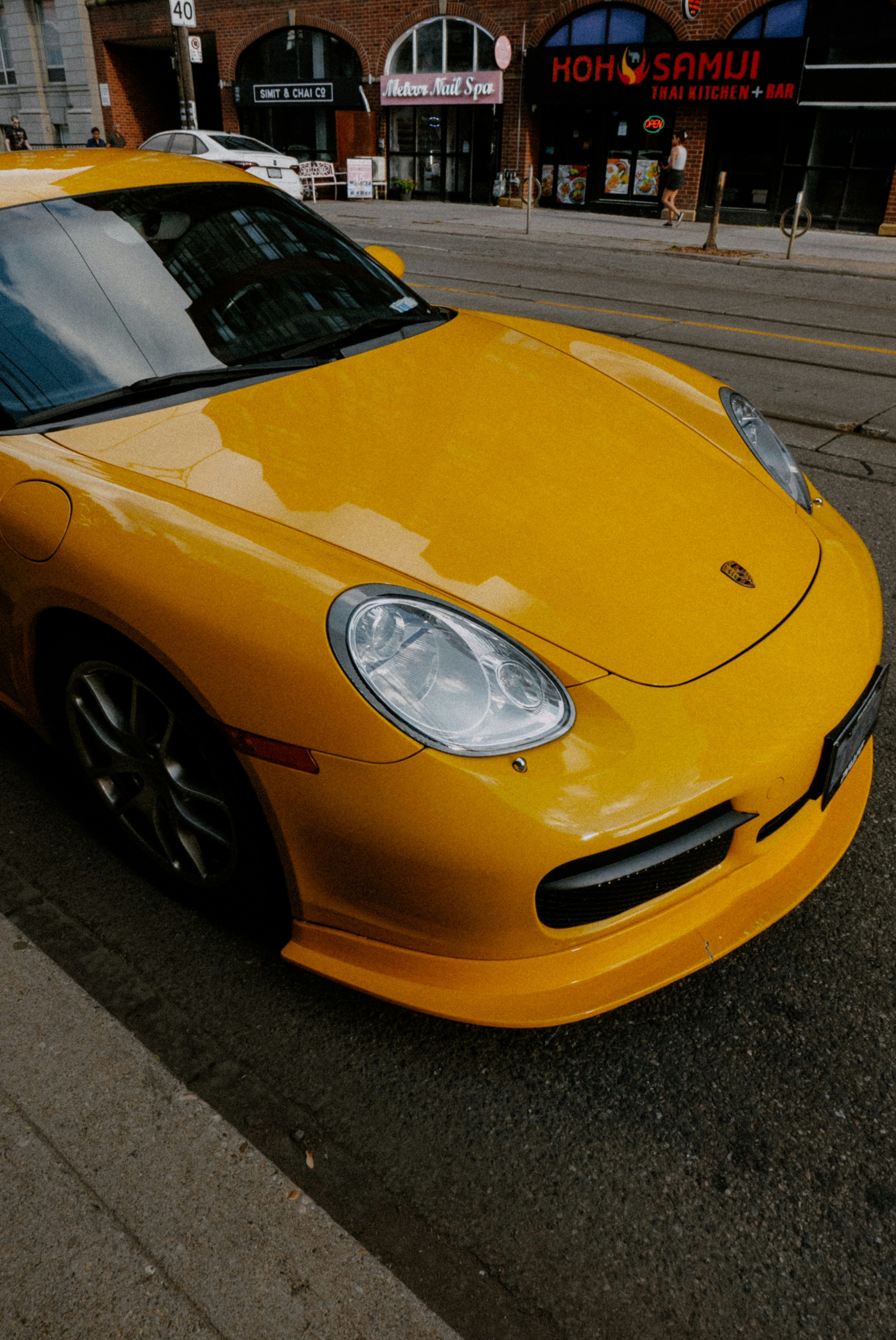 Yellow sports car parked on a city street.