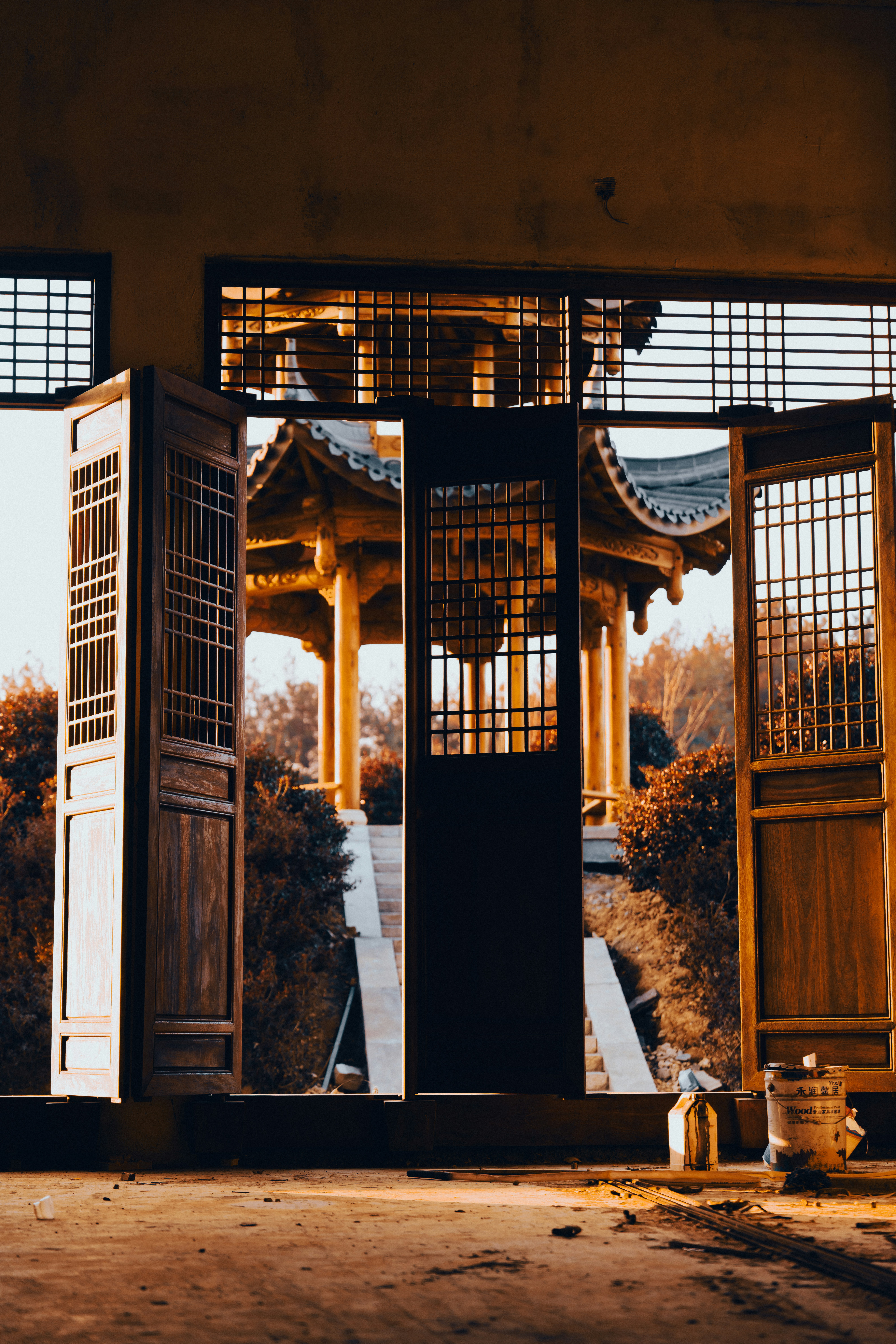Open wooden doors reveal a traditional pavilion structure.