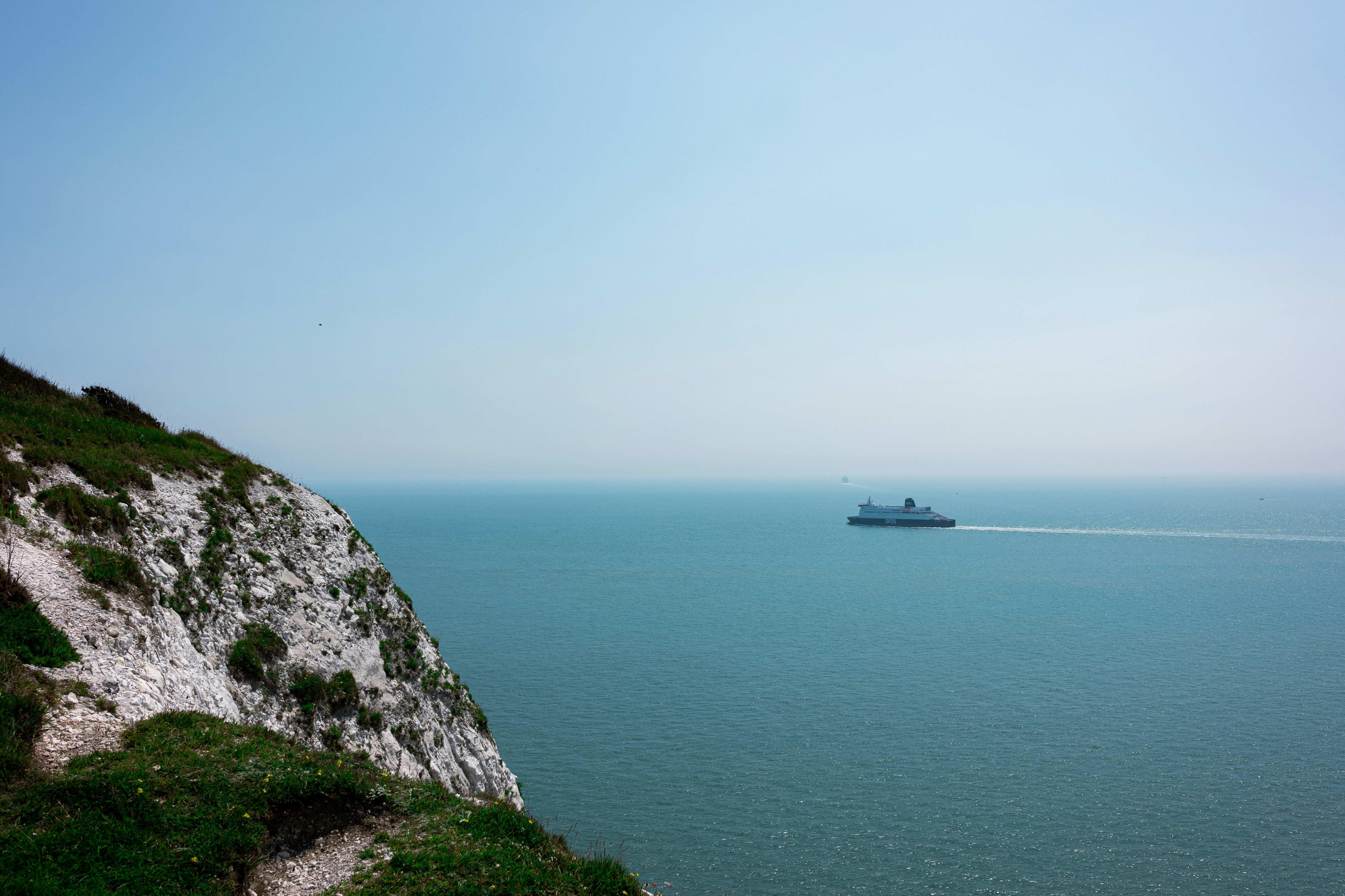 Ferry sailing on the ocean near white cliffs