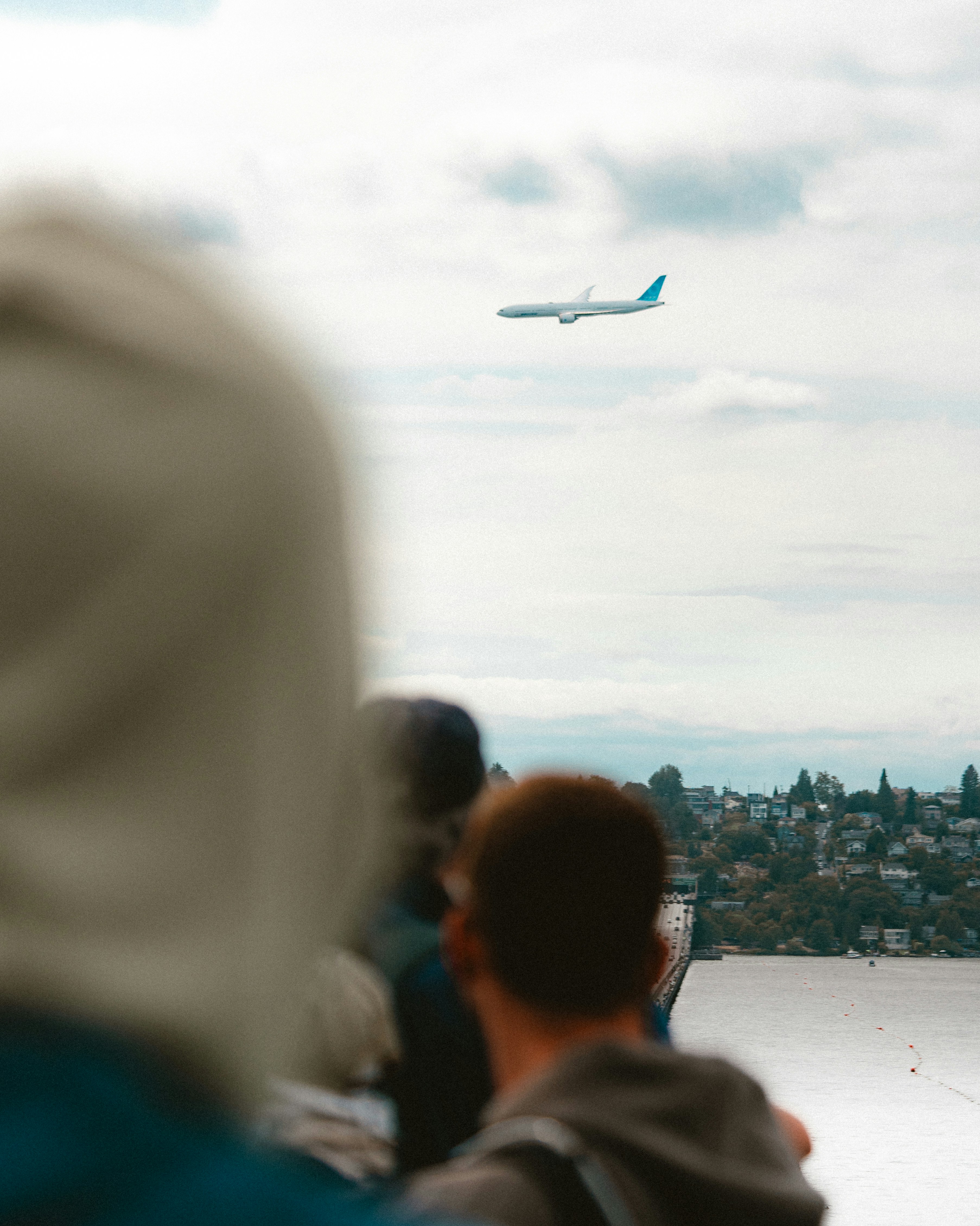 777x | Airplane flying over city and water