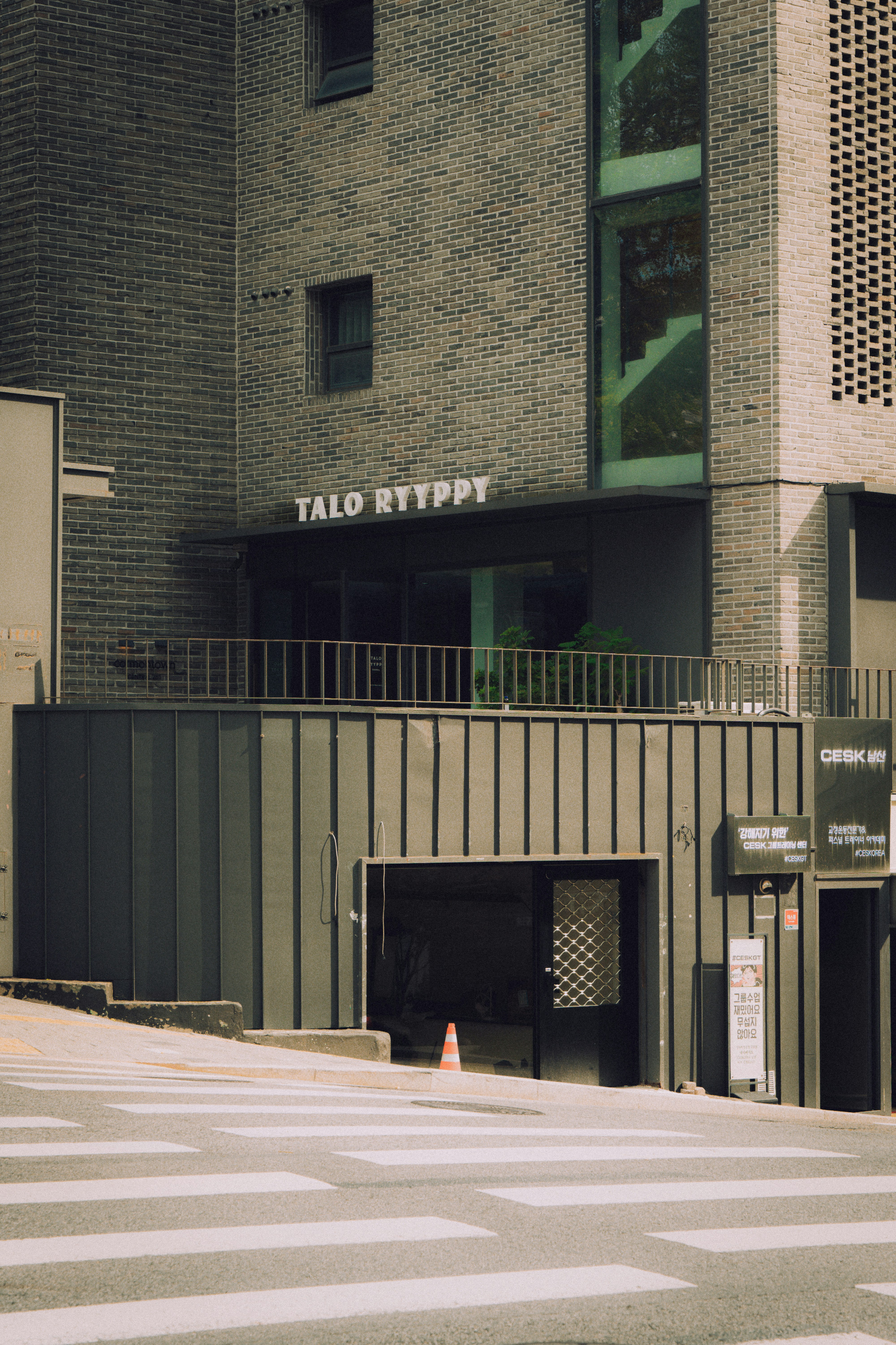 Modern building with signage and parking entrance.