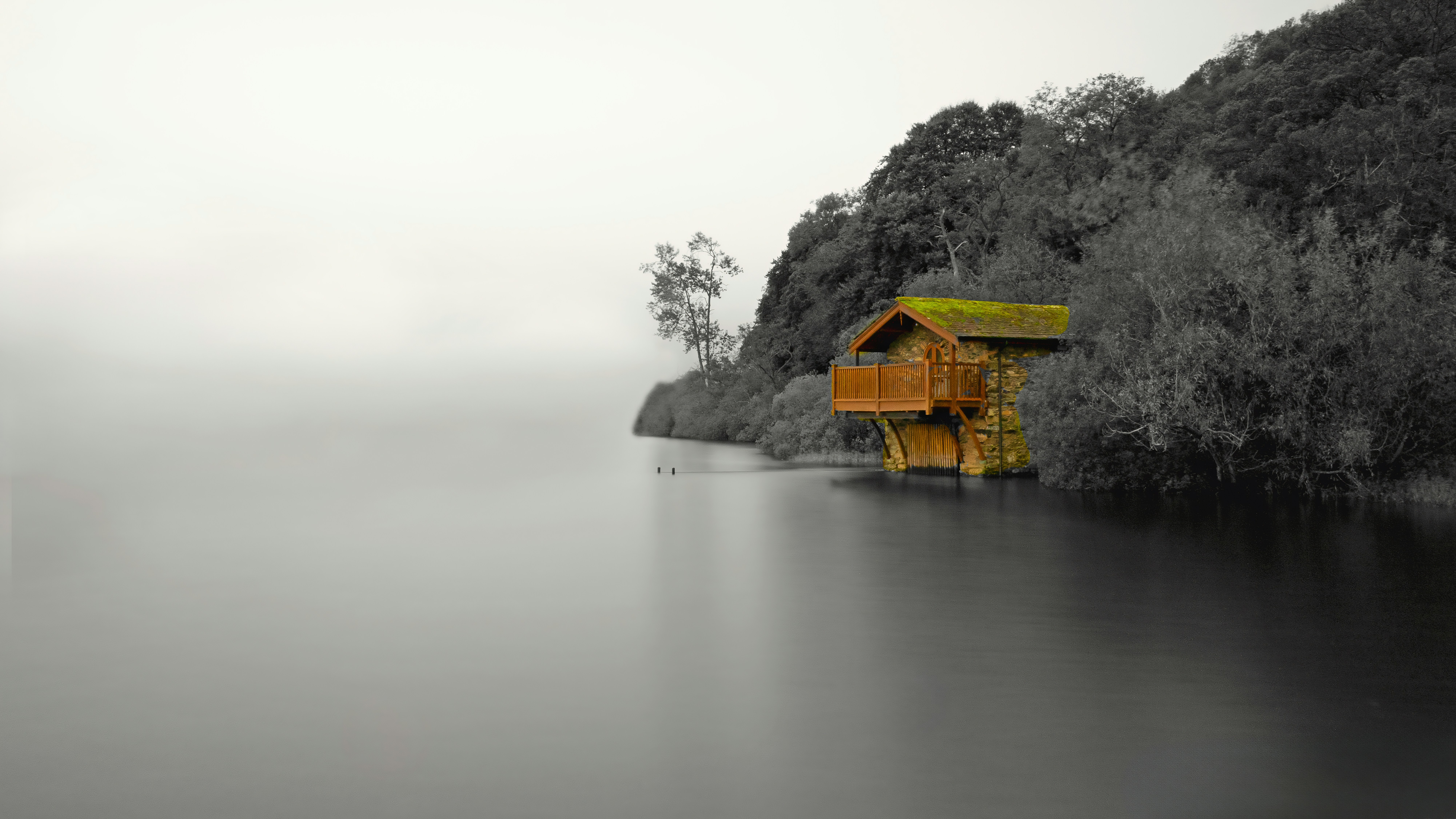 Boat House on an English lake | Wooden cabin on a misty lake with trees.