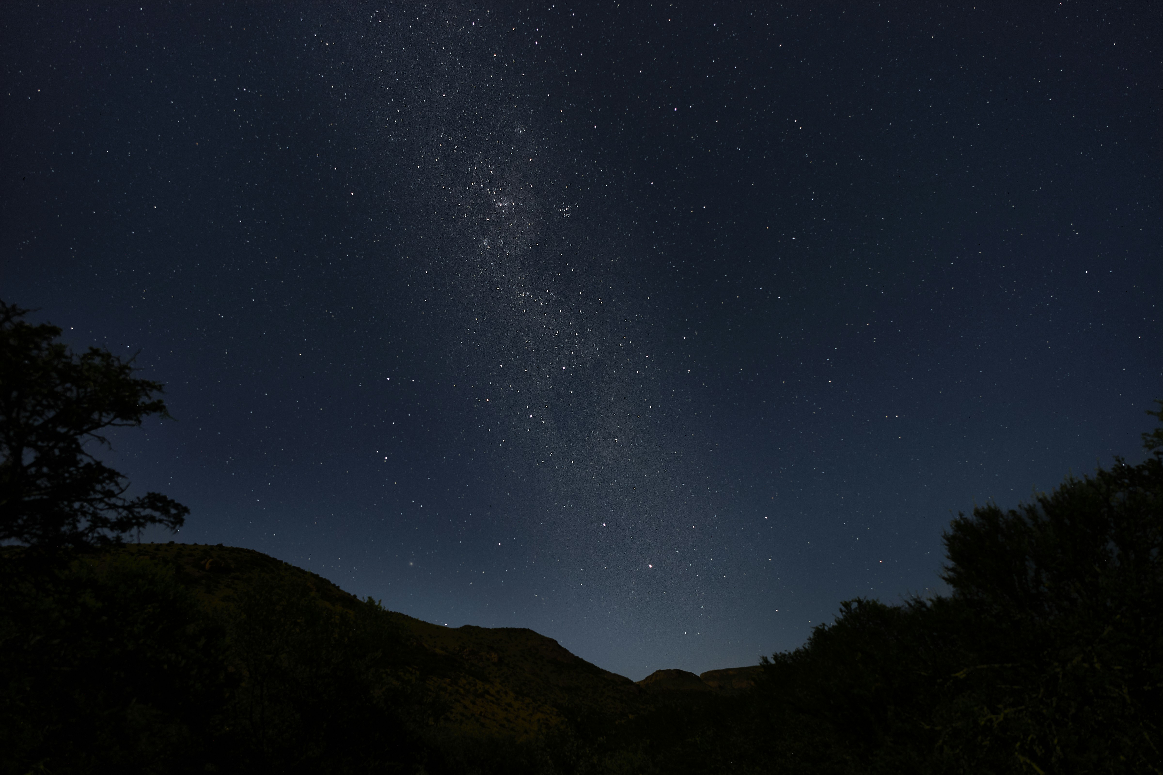 Starry night sky over silhouetted hills