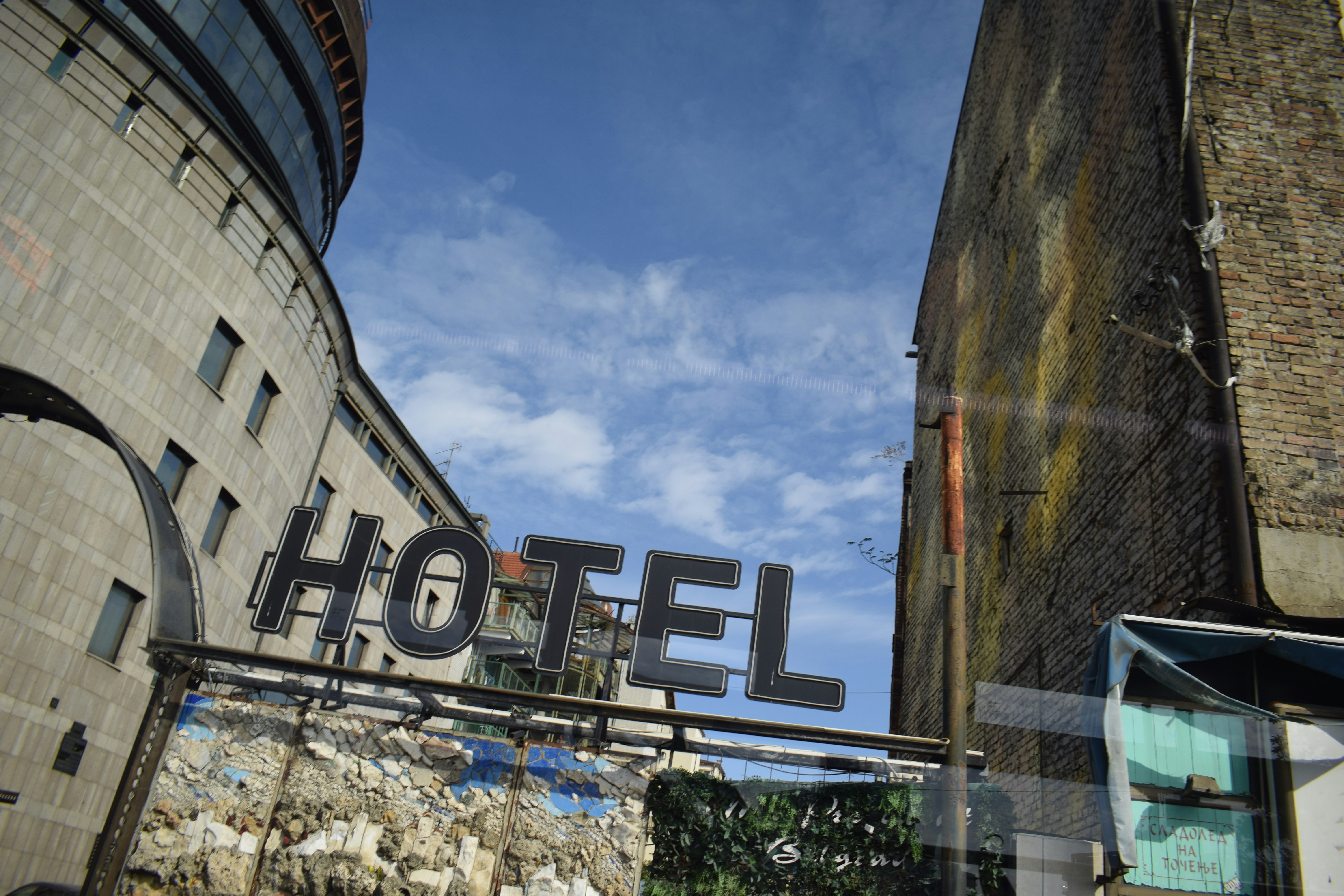 Hotel sign against a blue sky with clouds