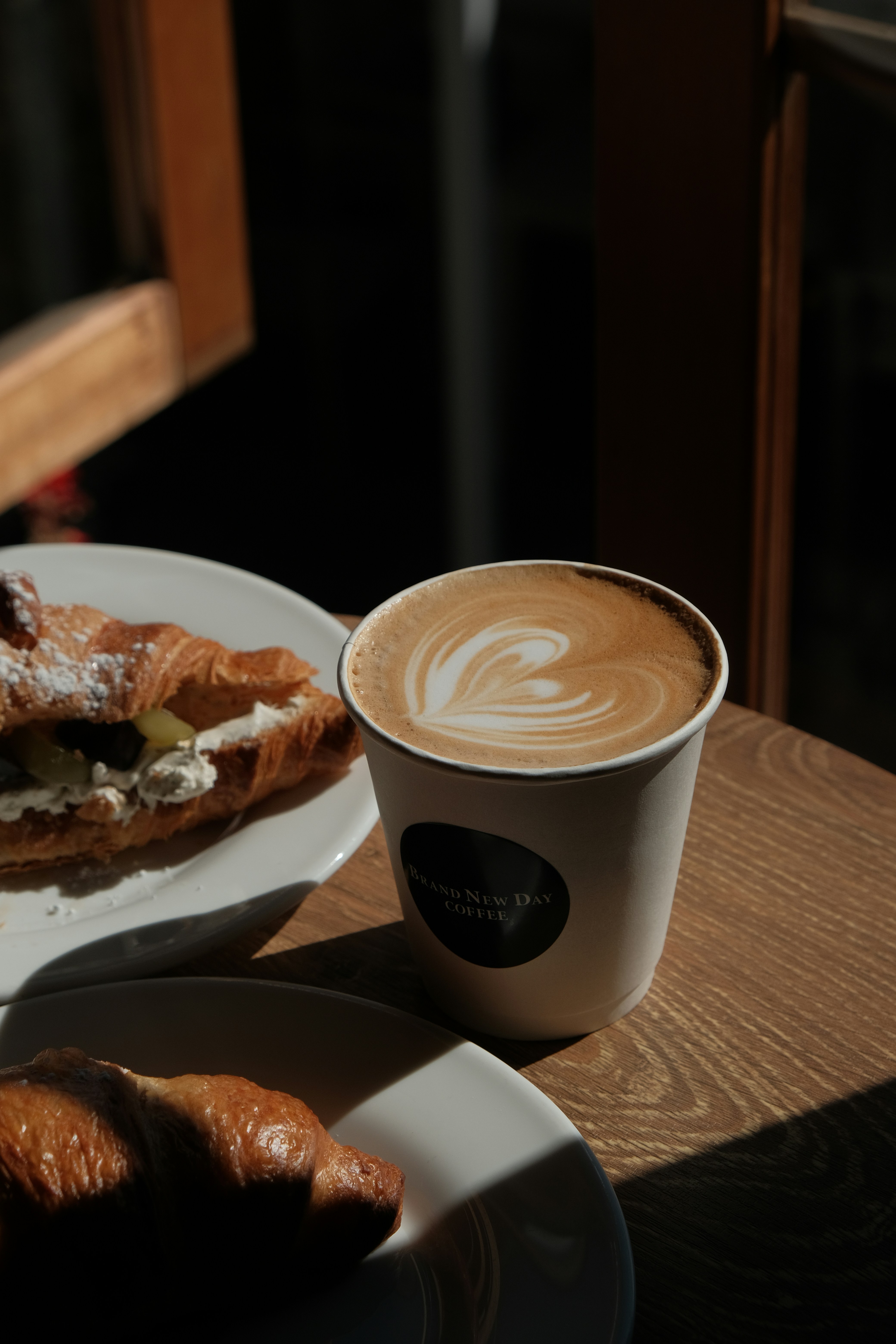 Latte art coffee with croissants on a wooden table