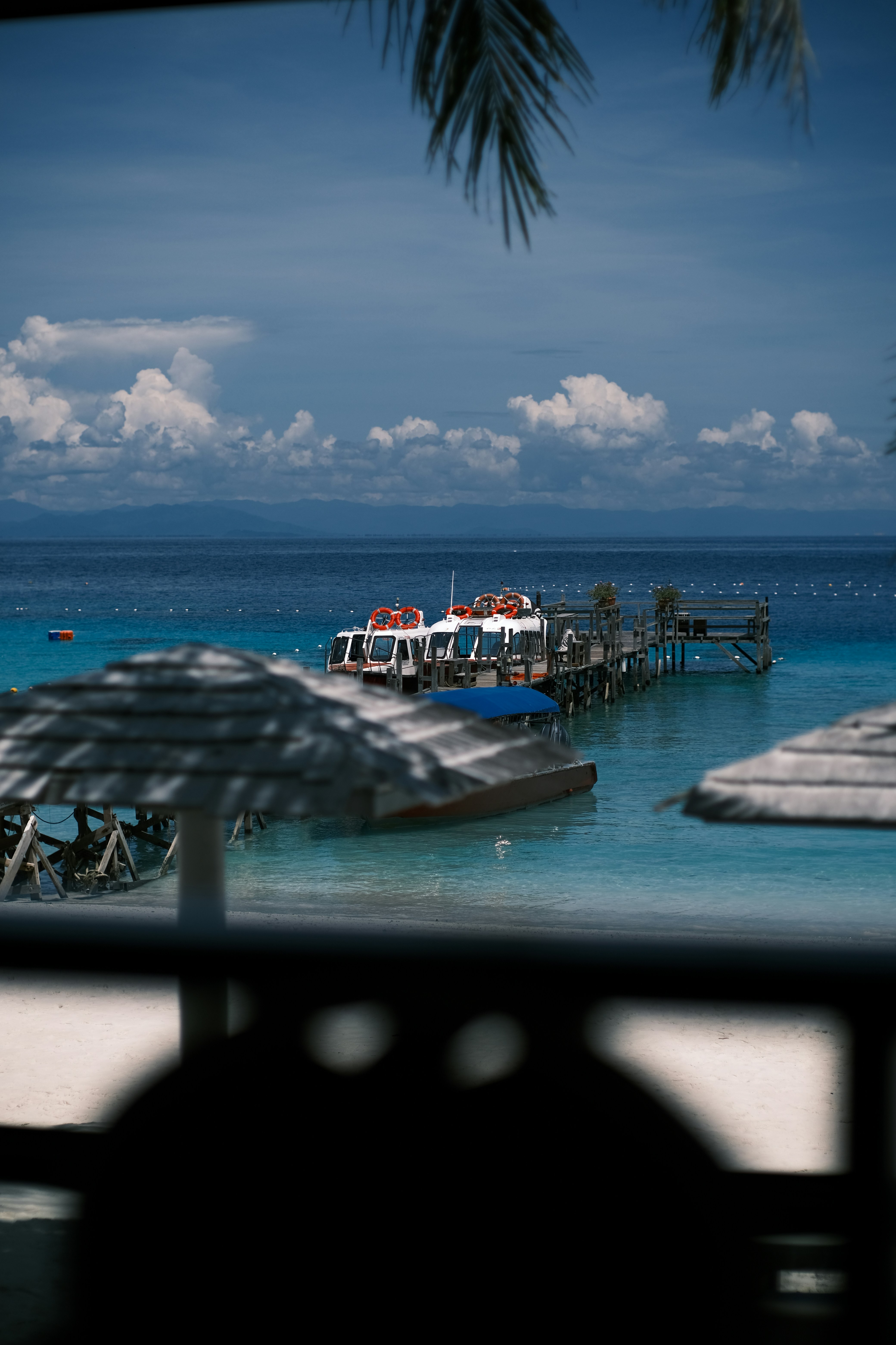 Boats docked at a pier on a clear blue ocean