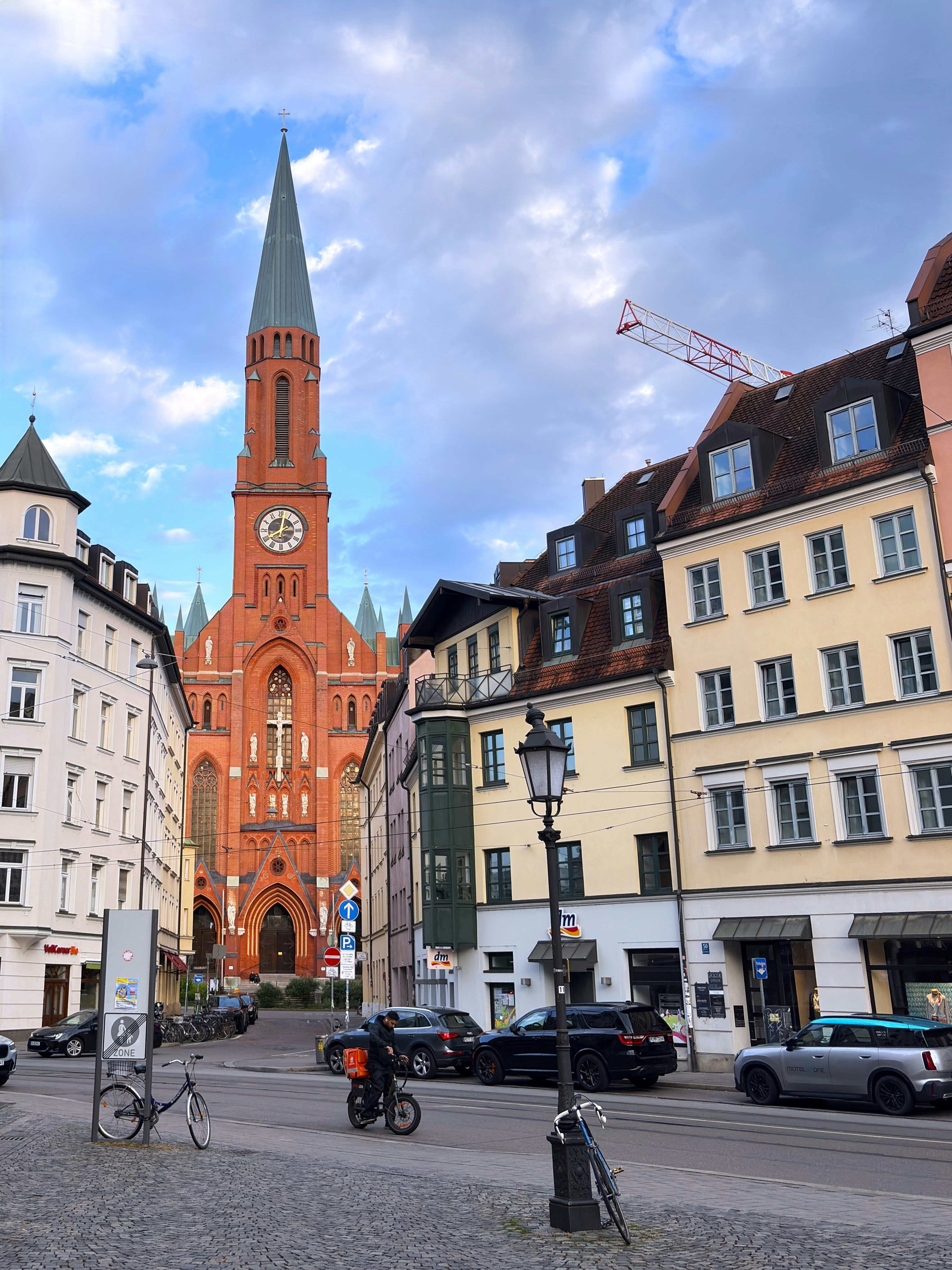 Munich, Germany | Tall brick church tower overlooks a city street.