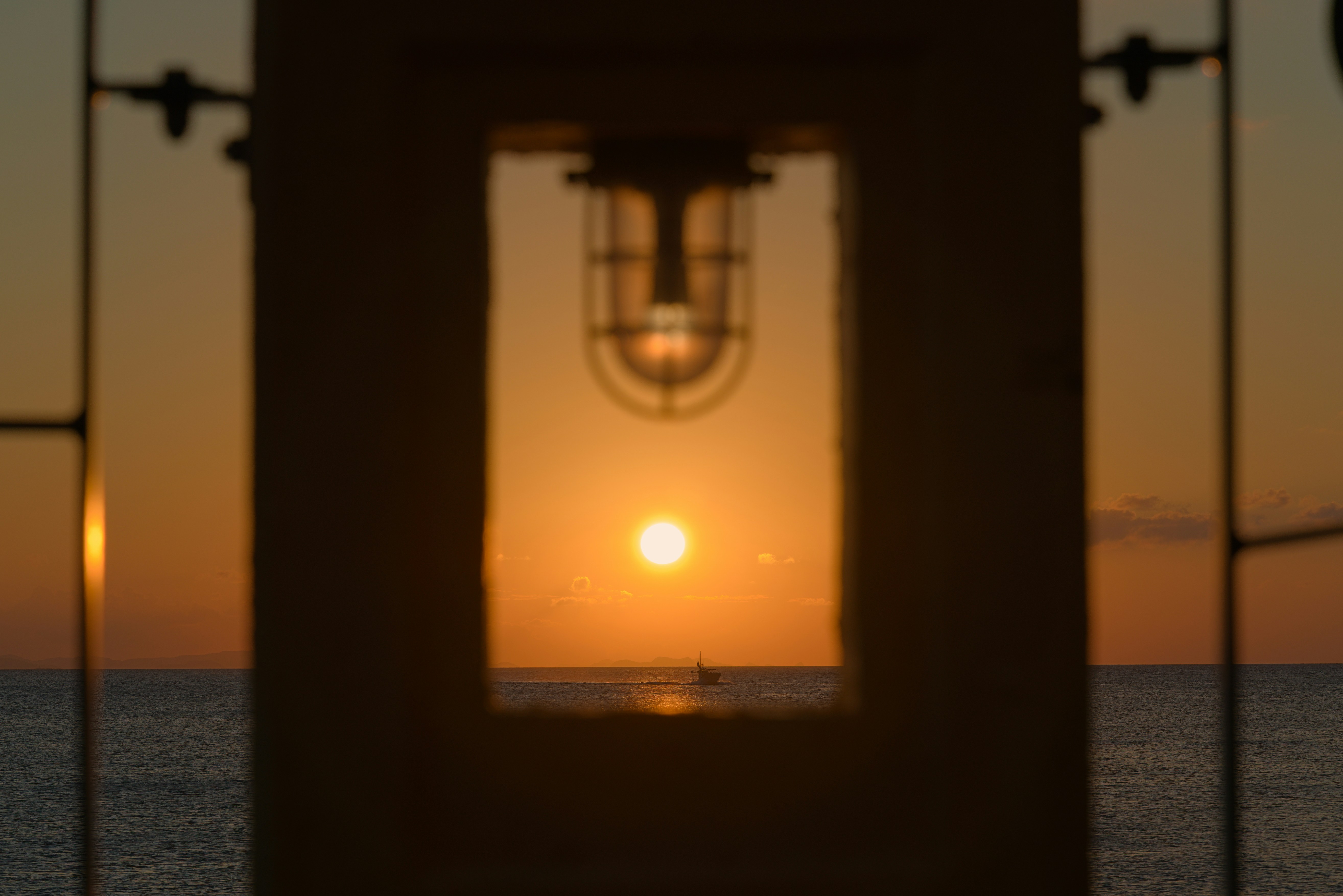 Sunset over the ocean seen through a window