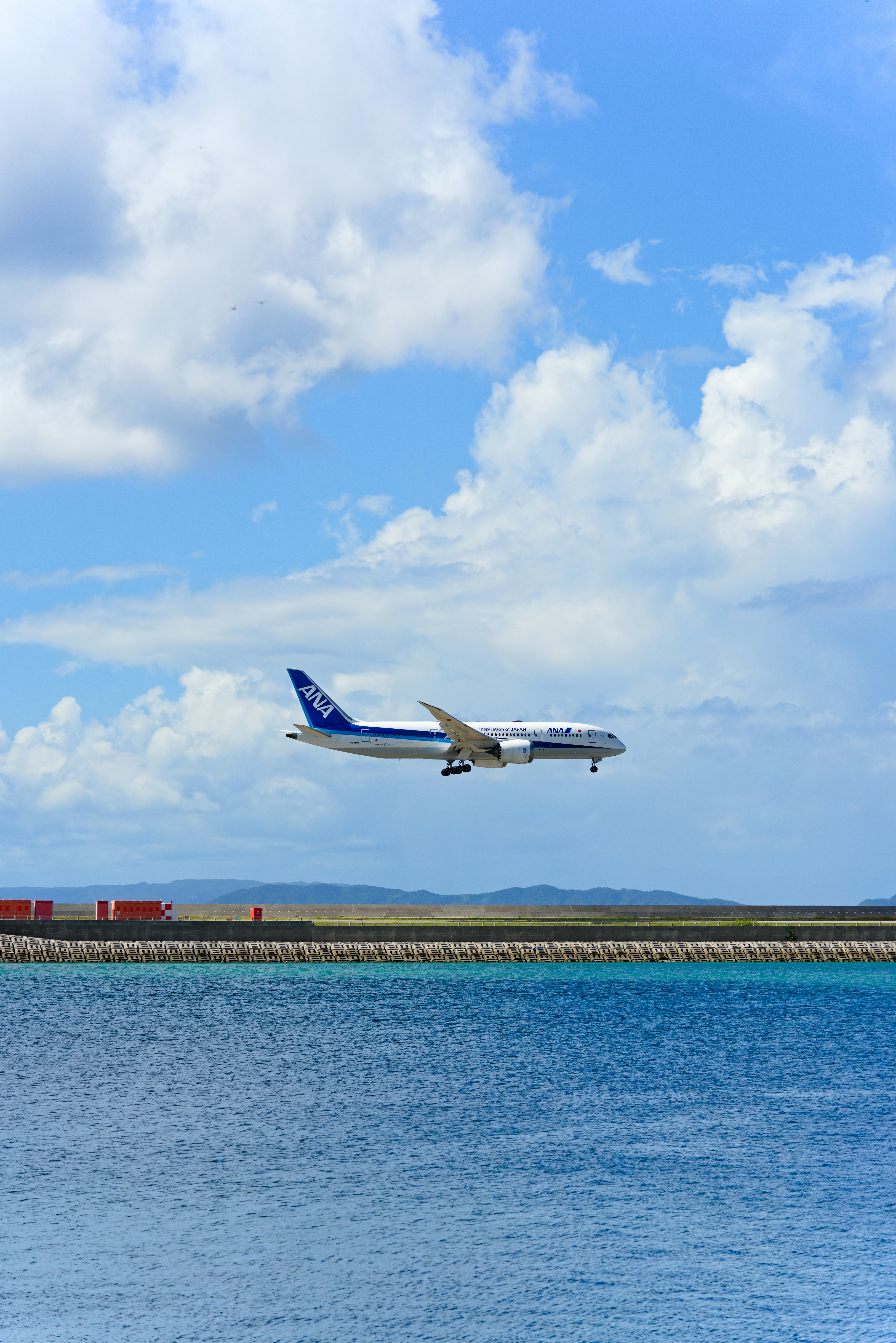 Airplane approaching runway over the ocean