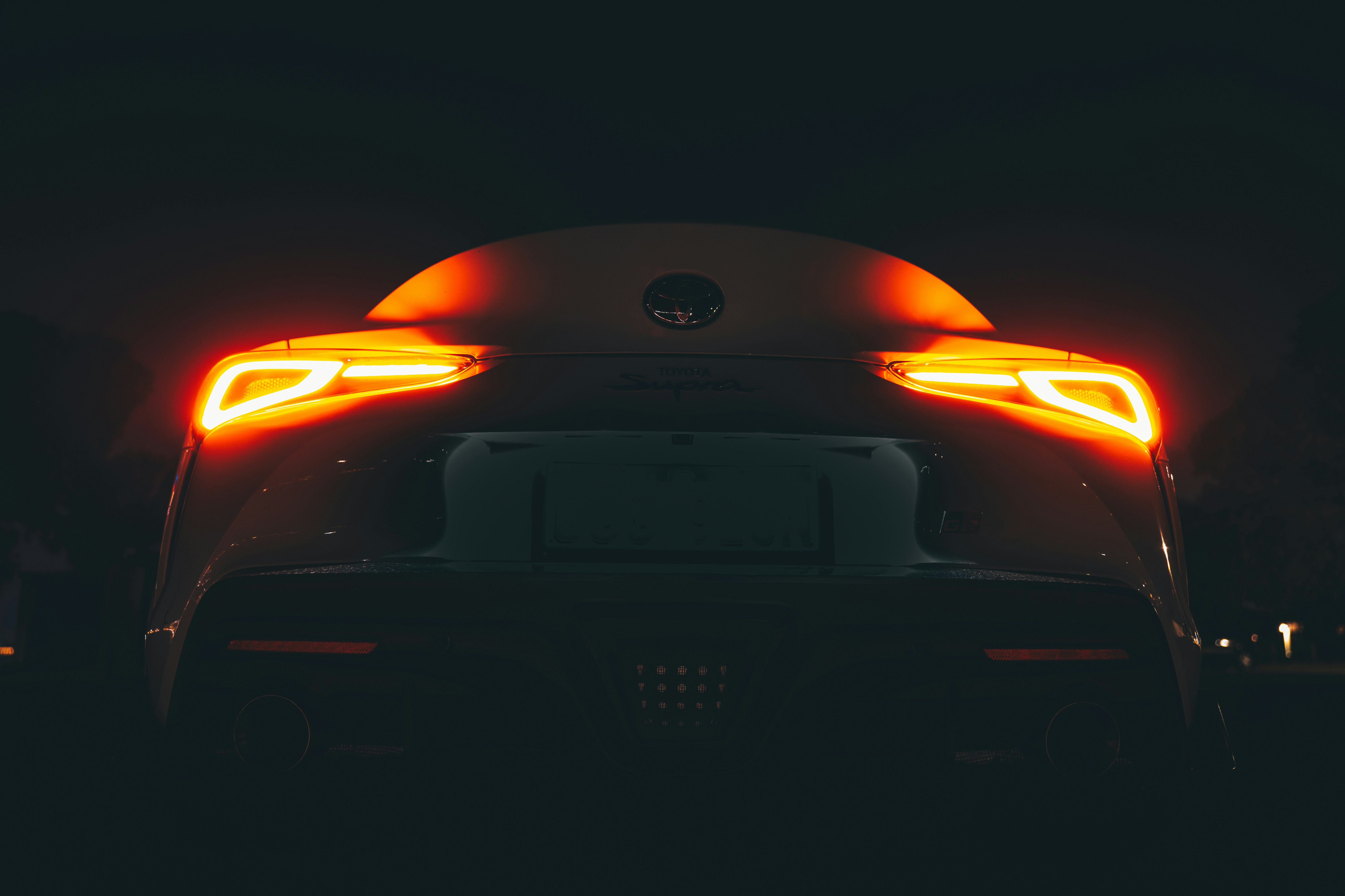 Rear view of a car with glowing taillights at night