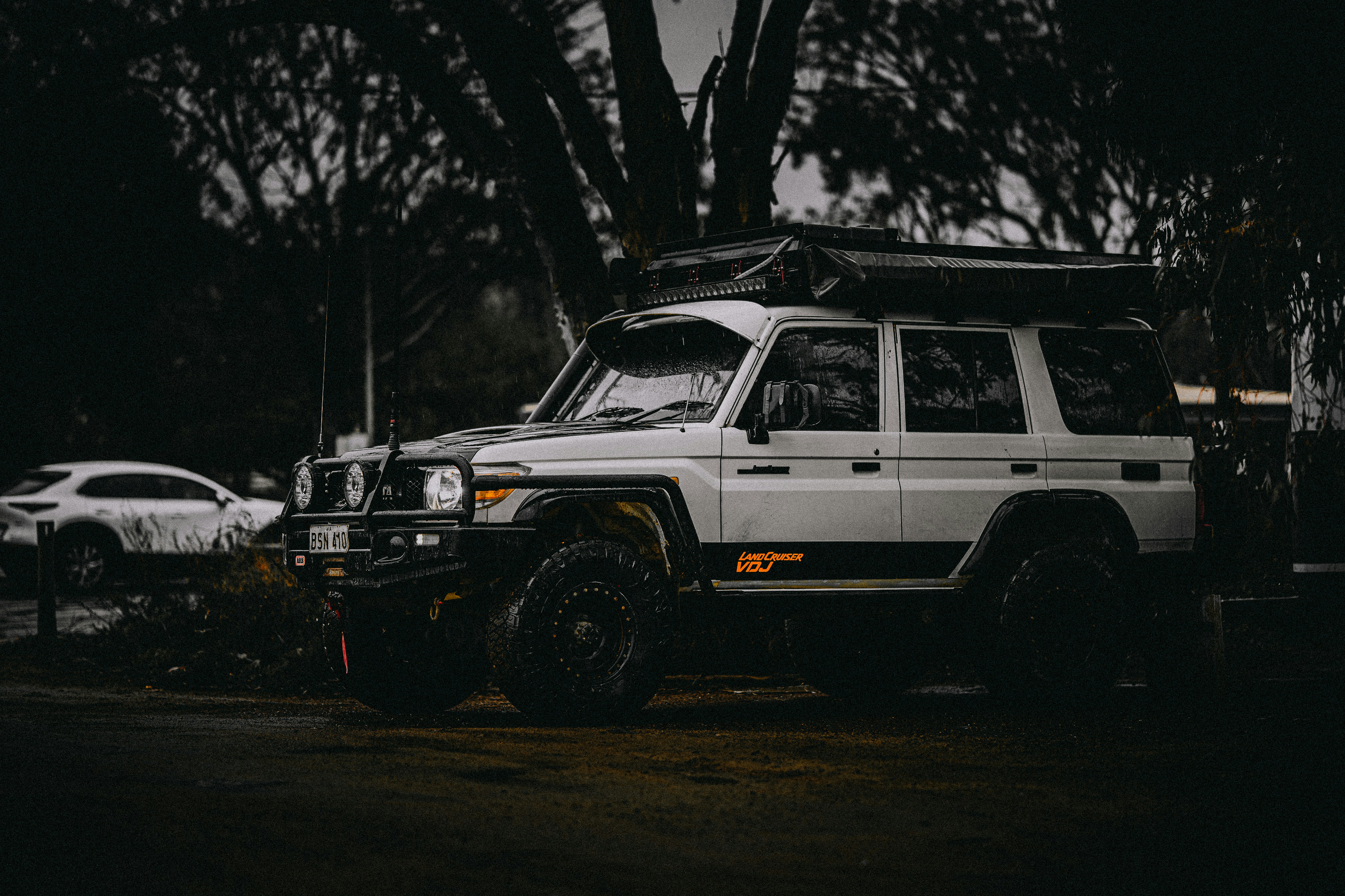 White off-road vehicle with rooftop tent parked outdoors. photo – Free ...