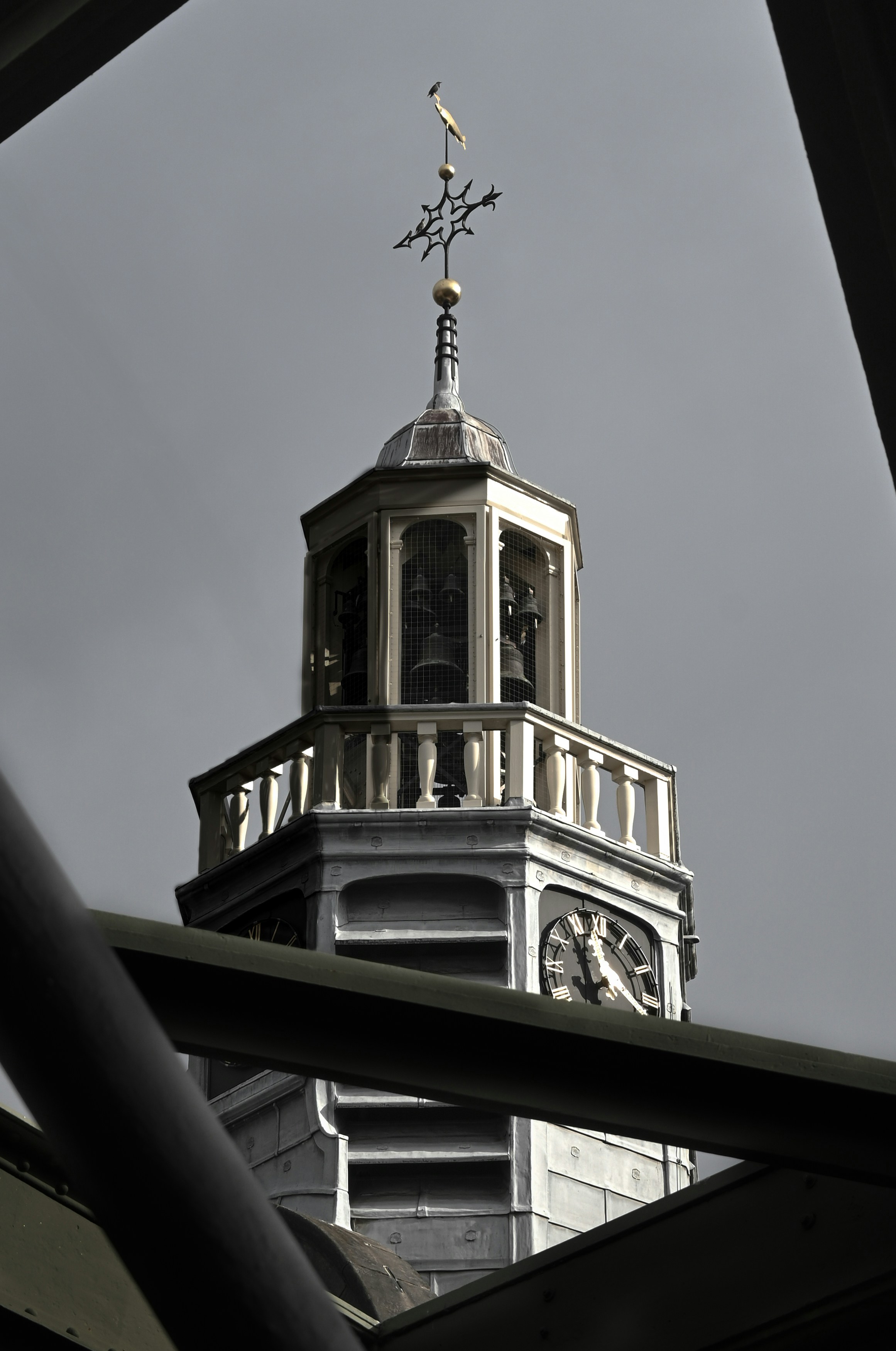 A church tower with a clock and weather vane.