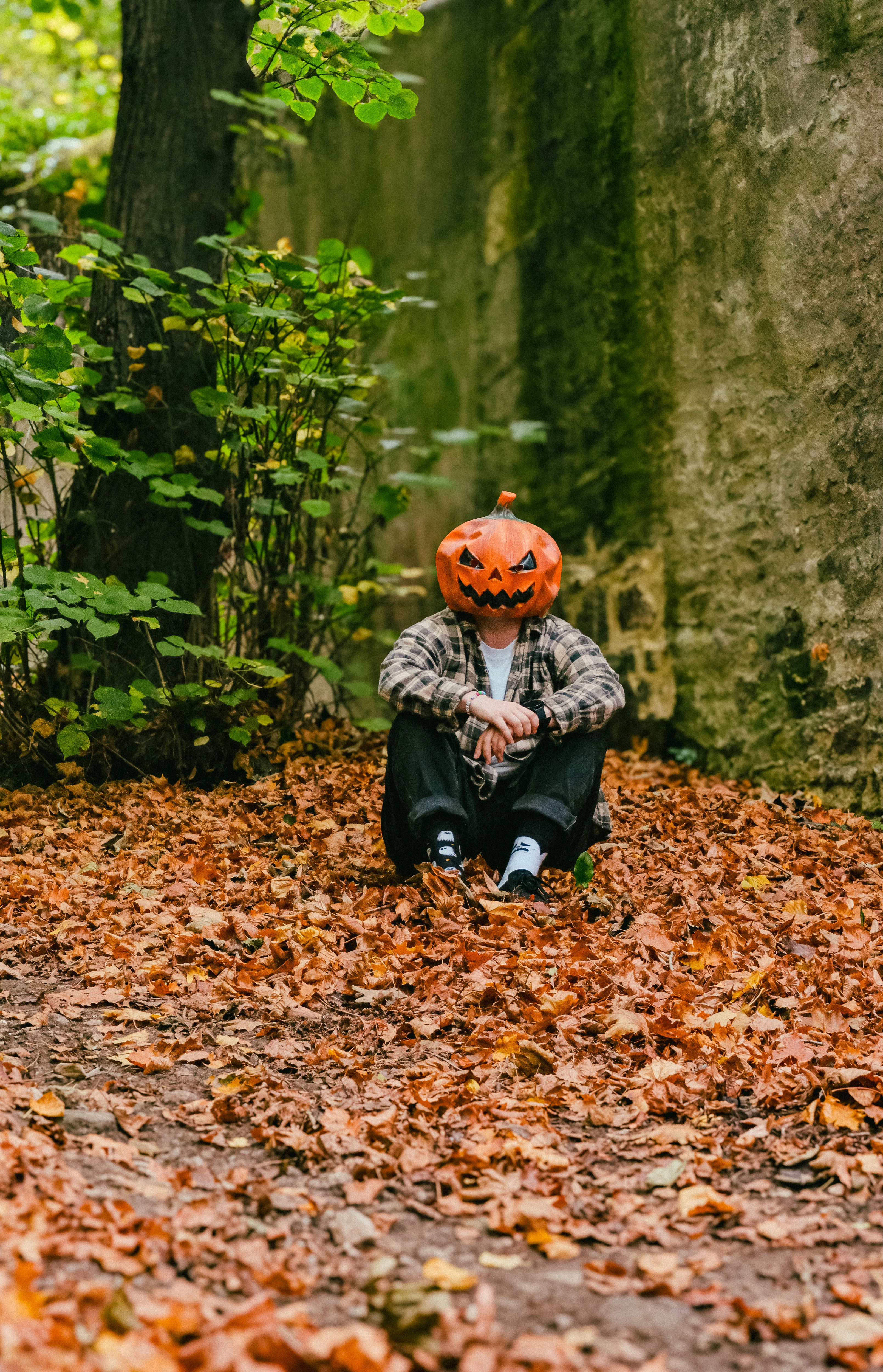 Happy Halloween 🎃 | Person with pumpkin head sitting in autumn leaves