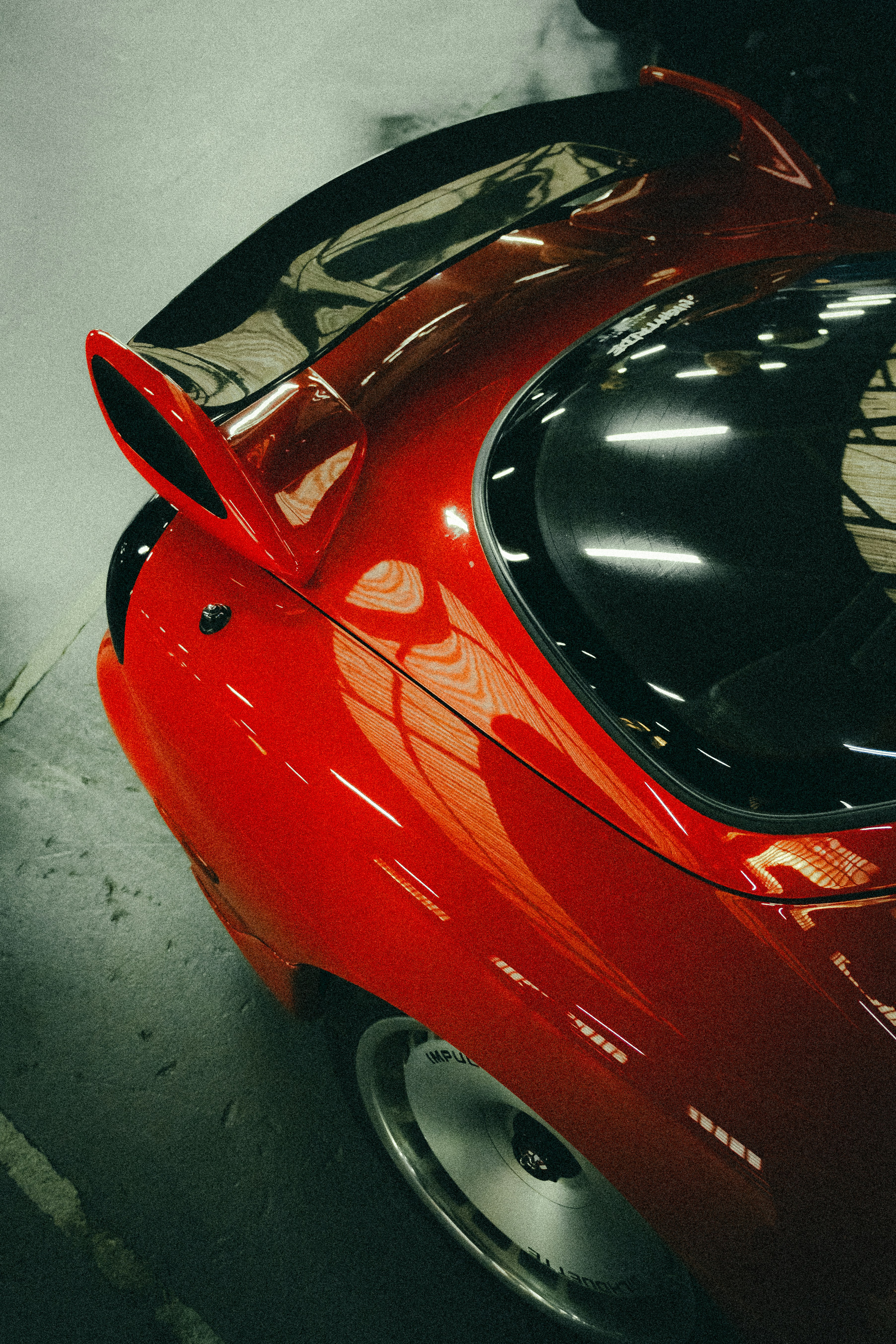Close-up of a shiny red sports car with spoiler.