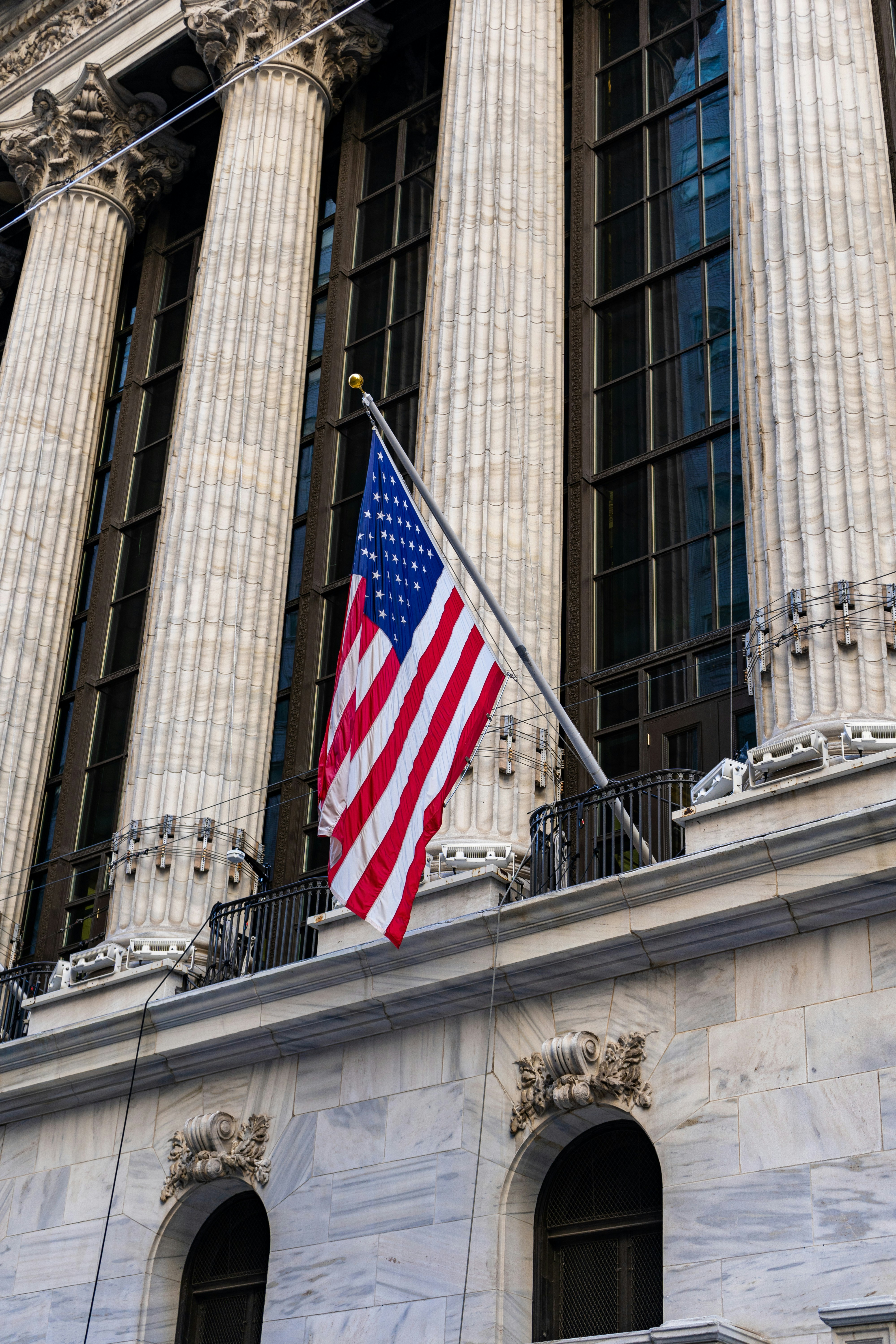 American flag on a marble building facade.