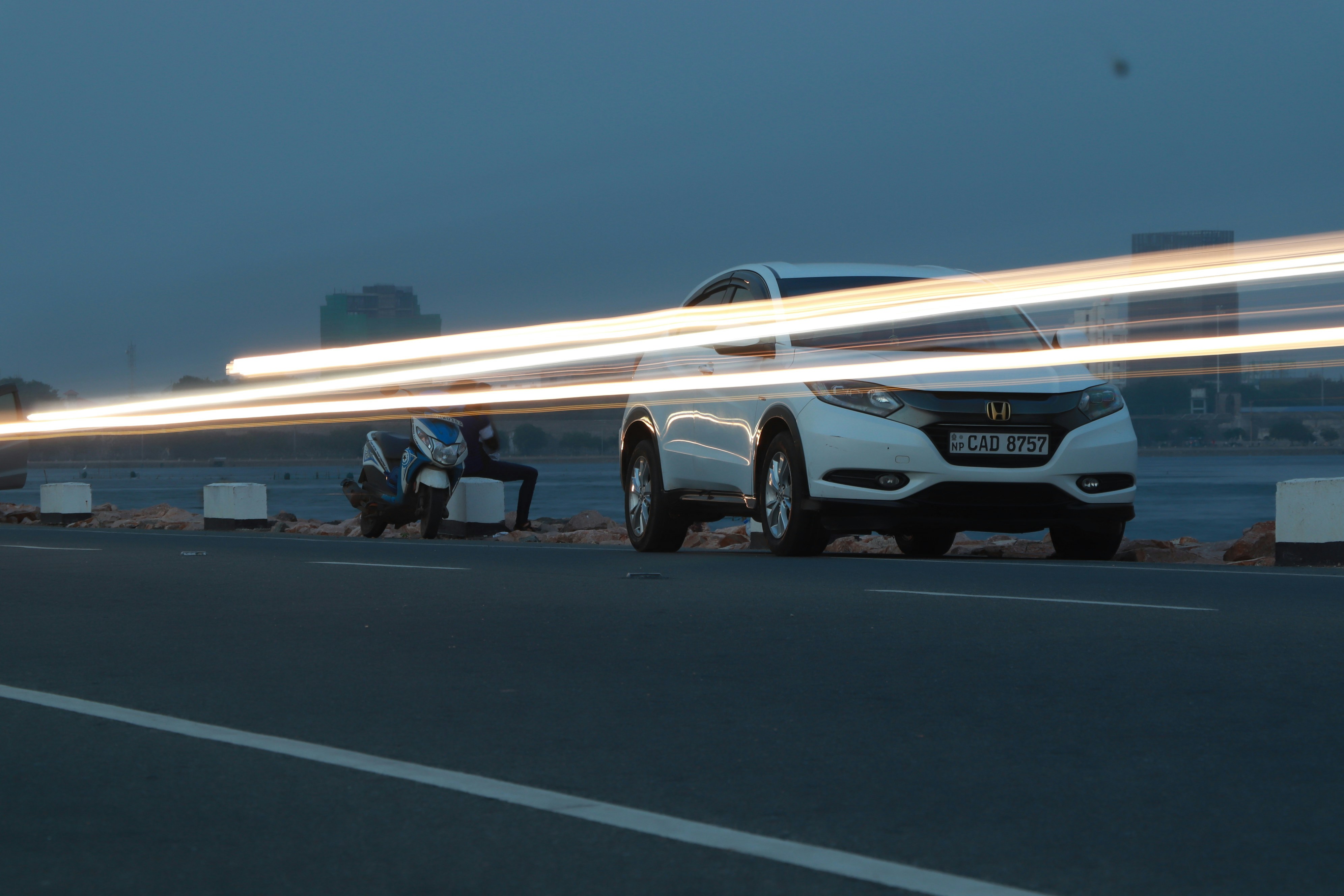 Light trails from a passing vehicle on a road.