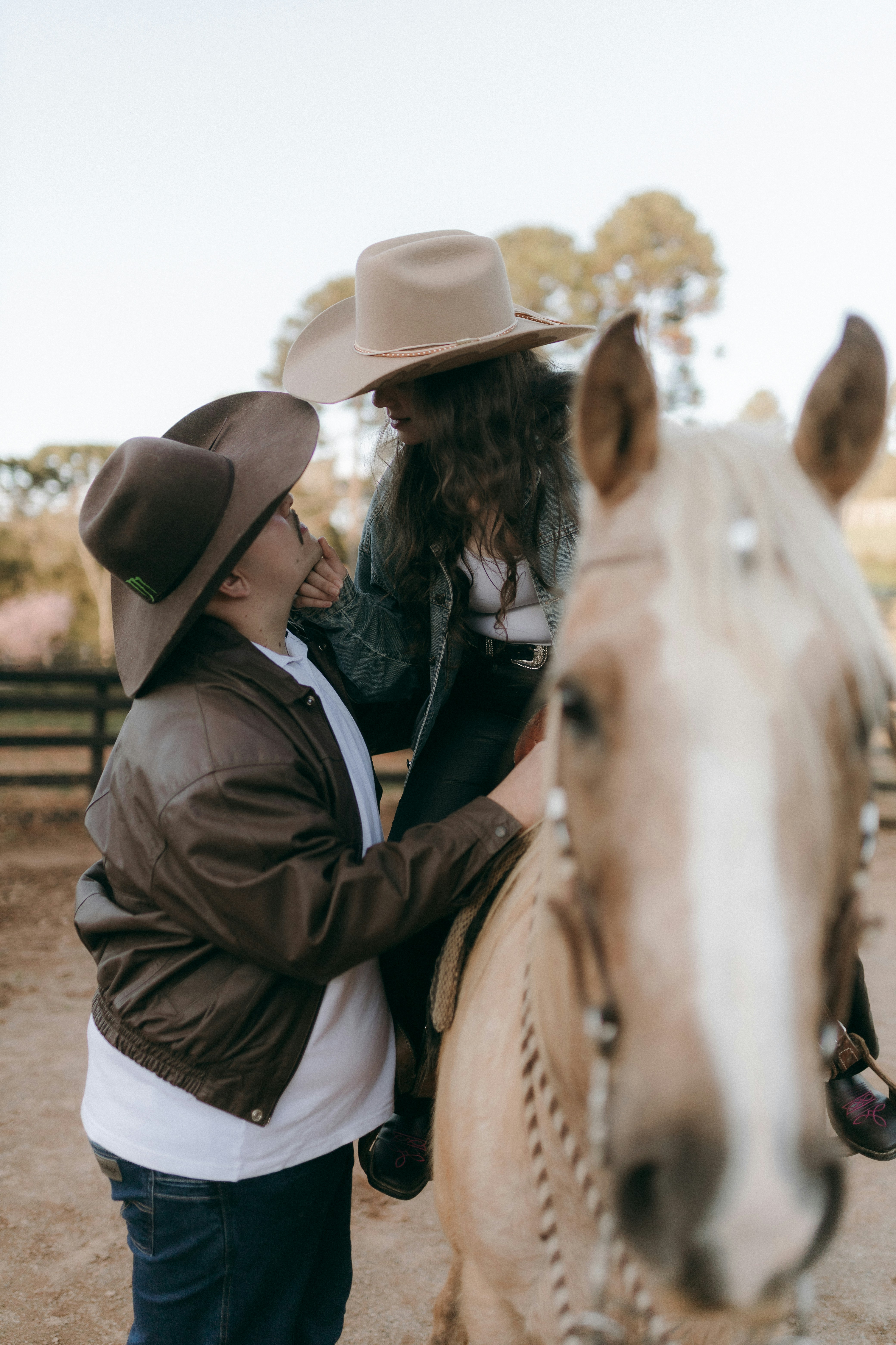 Two people in cowboy hats on a horse