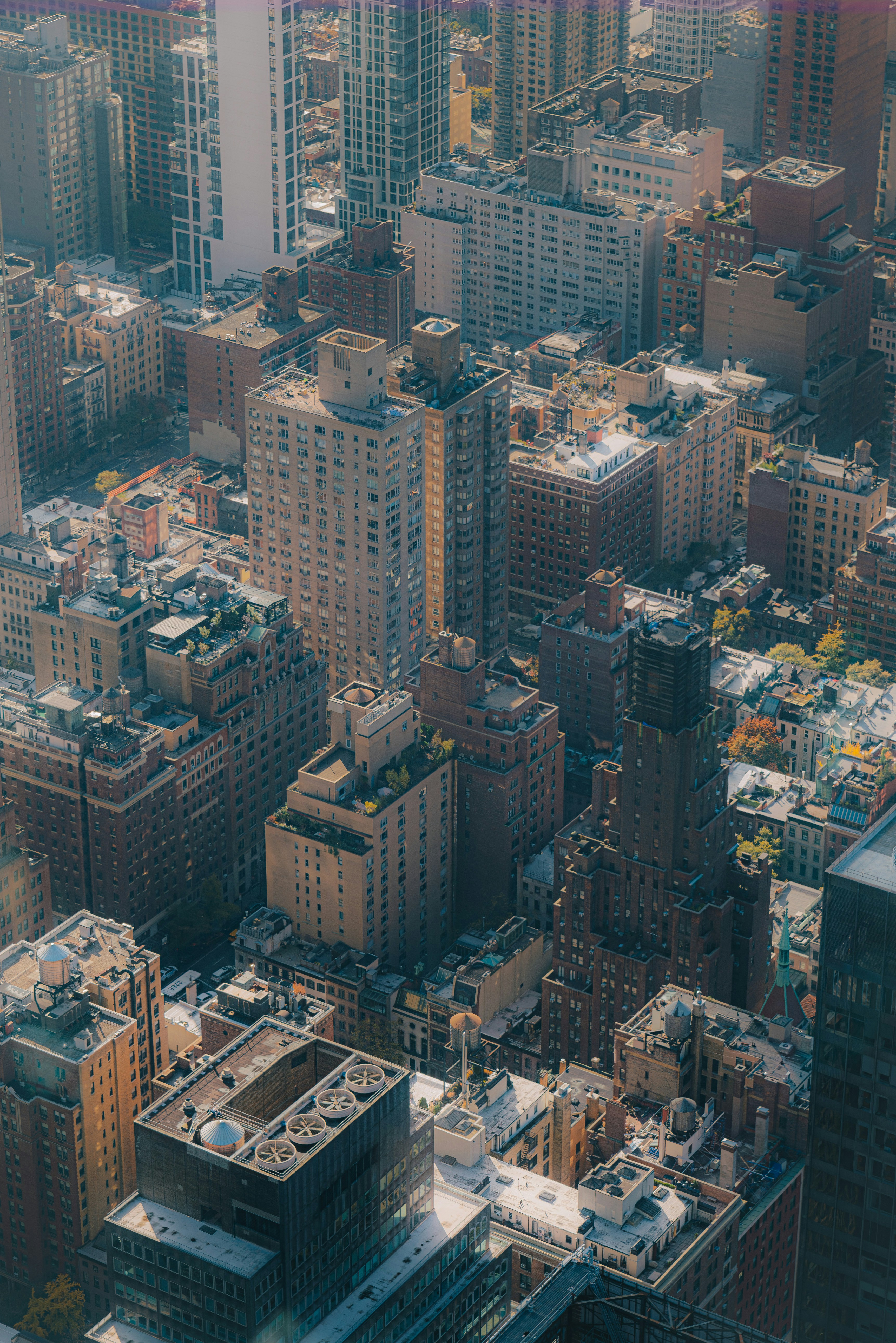 Aerial view of dense city buildings under sunlight.
