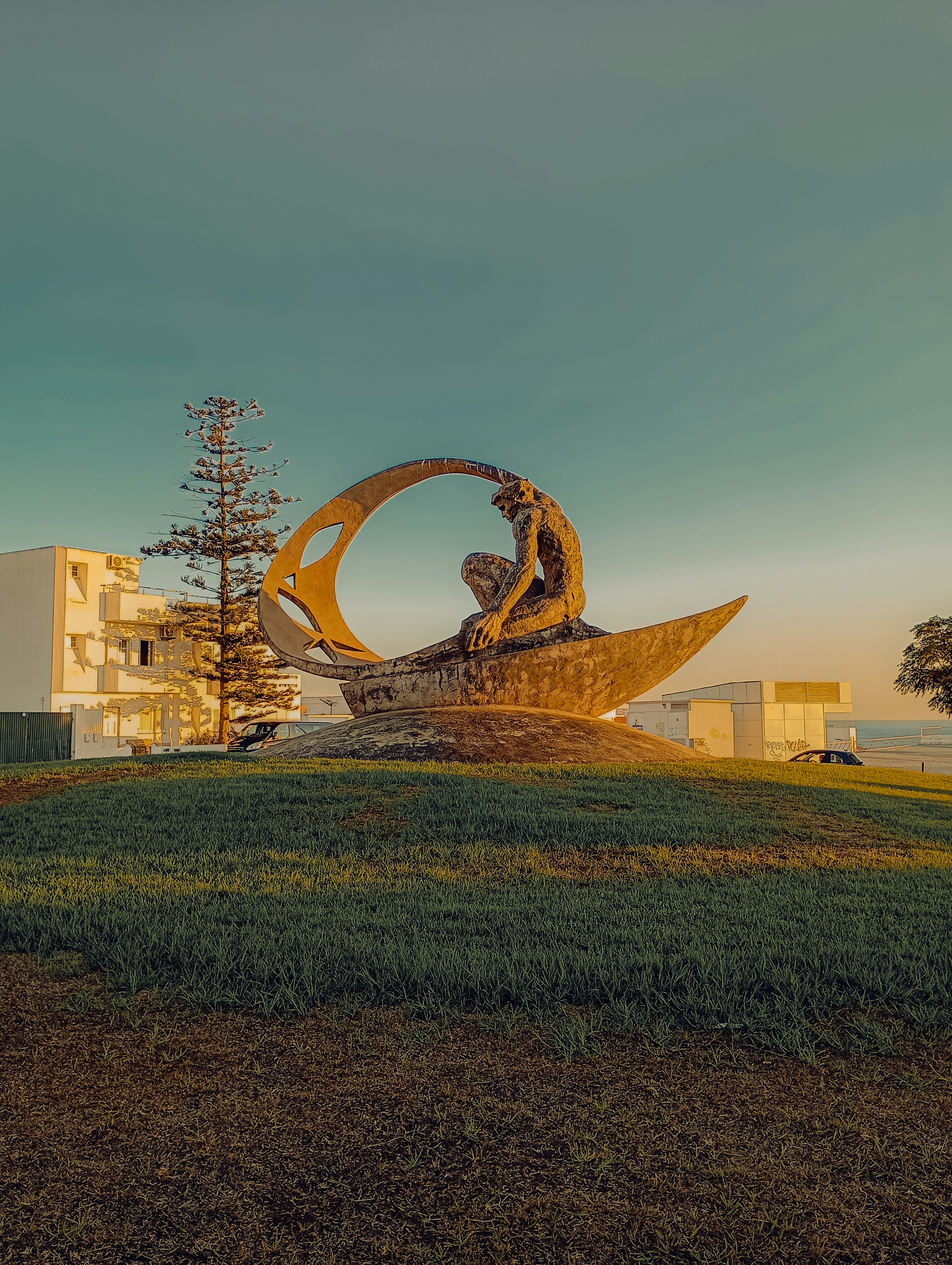 Sculpture of a person in a boat under an arch.