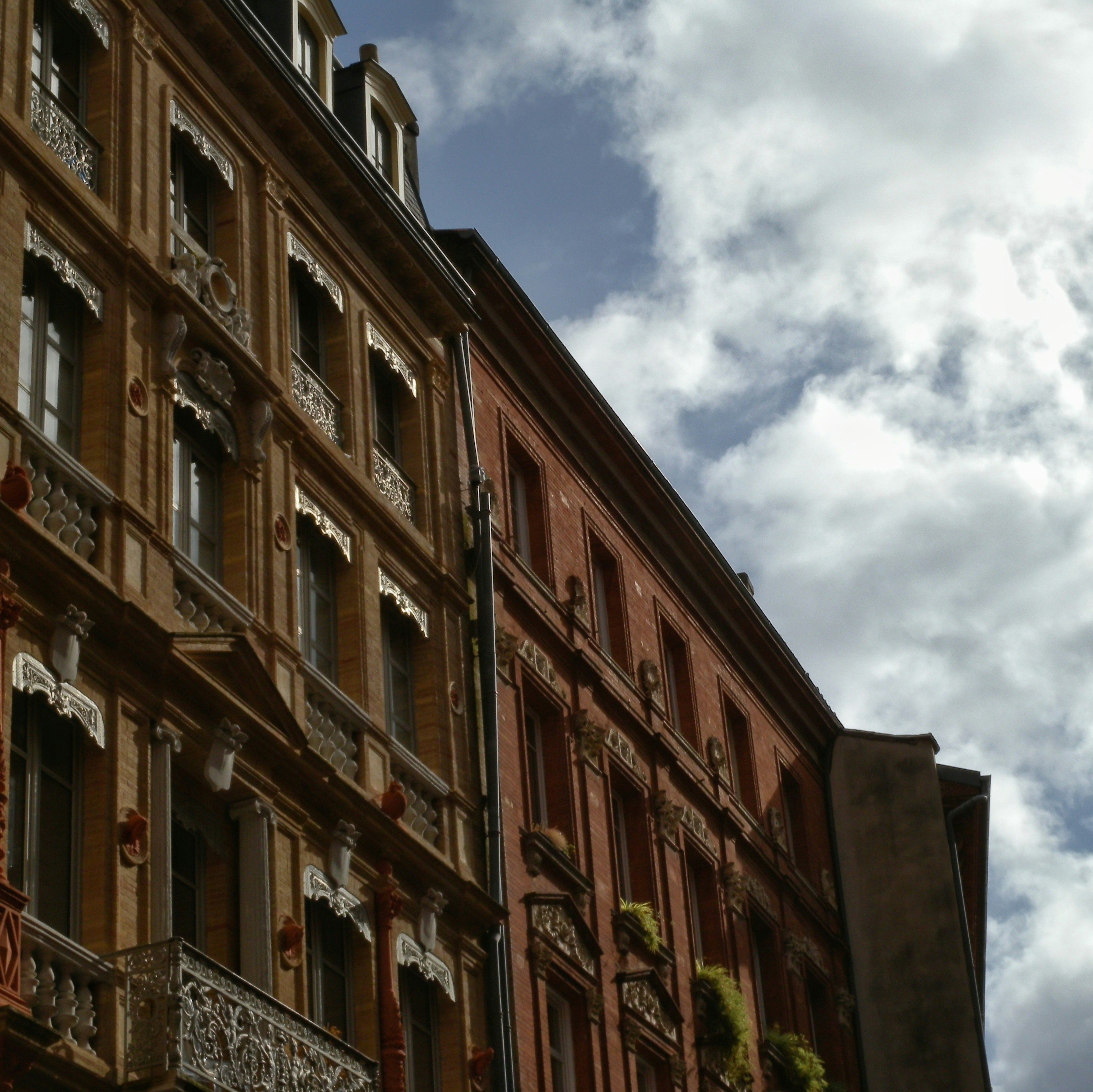 Two historic buildings against a cloudy sky