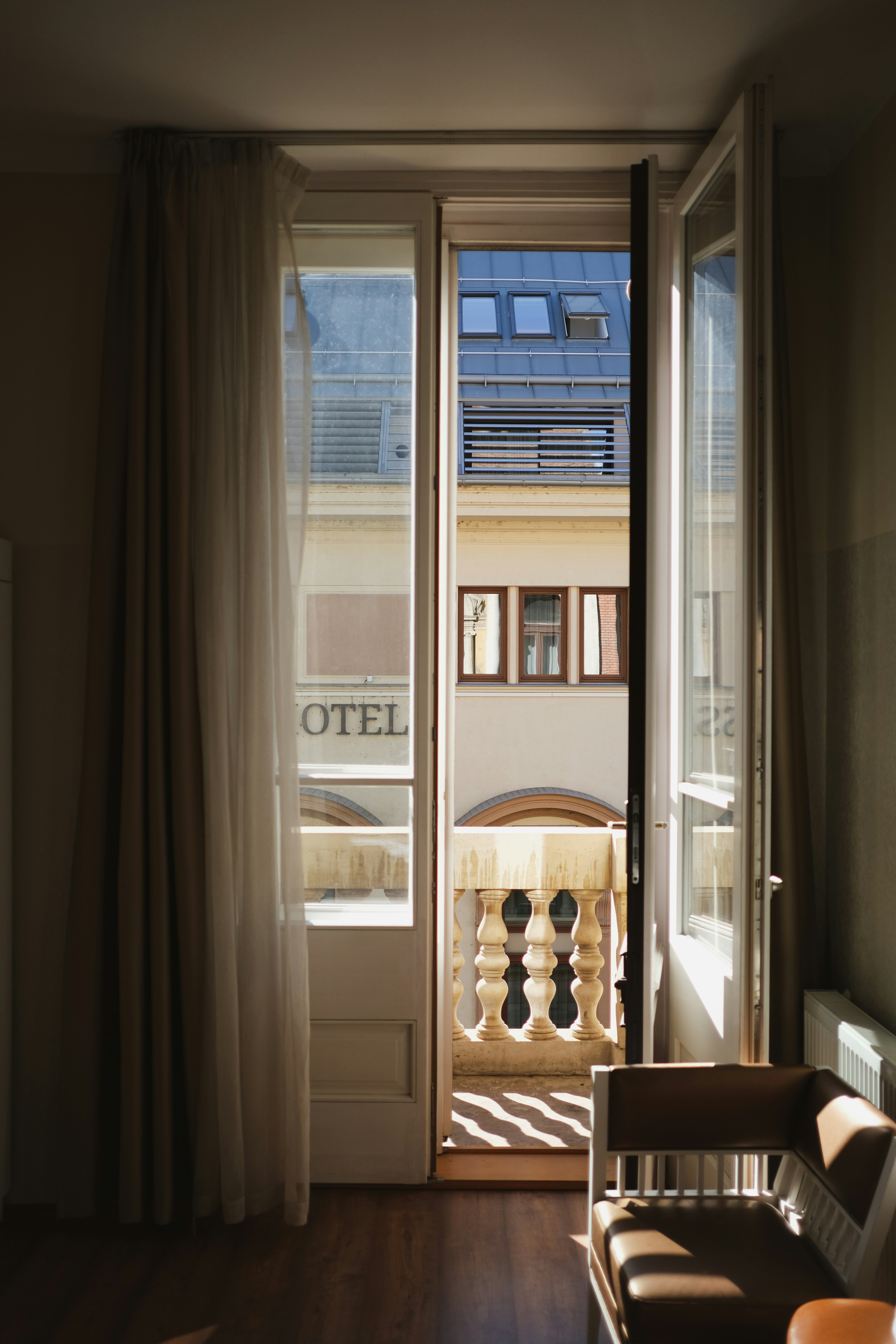 View through open balcony doors to city buildings