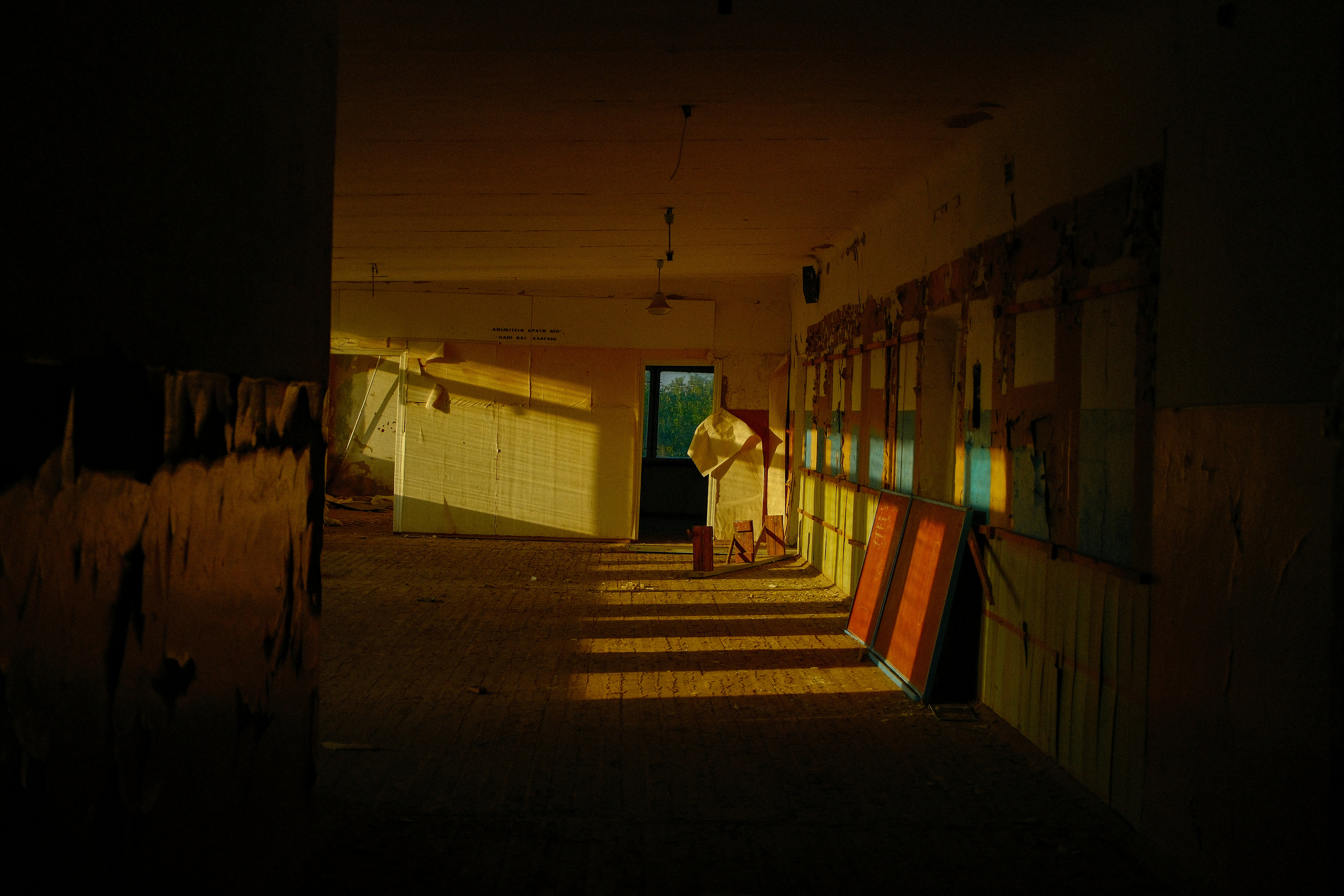 Sunlight streams into an empty hallway with colorful reflections.