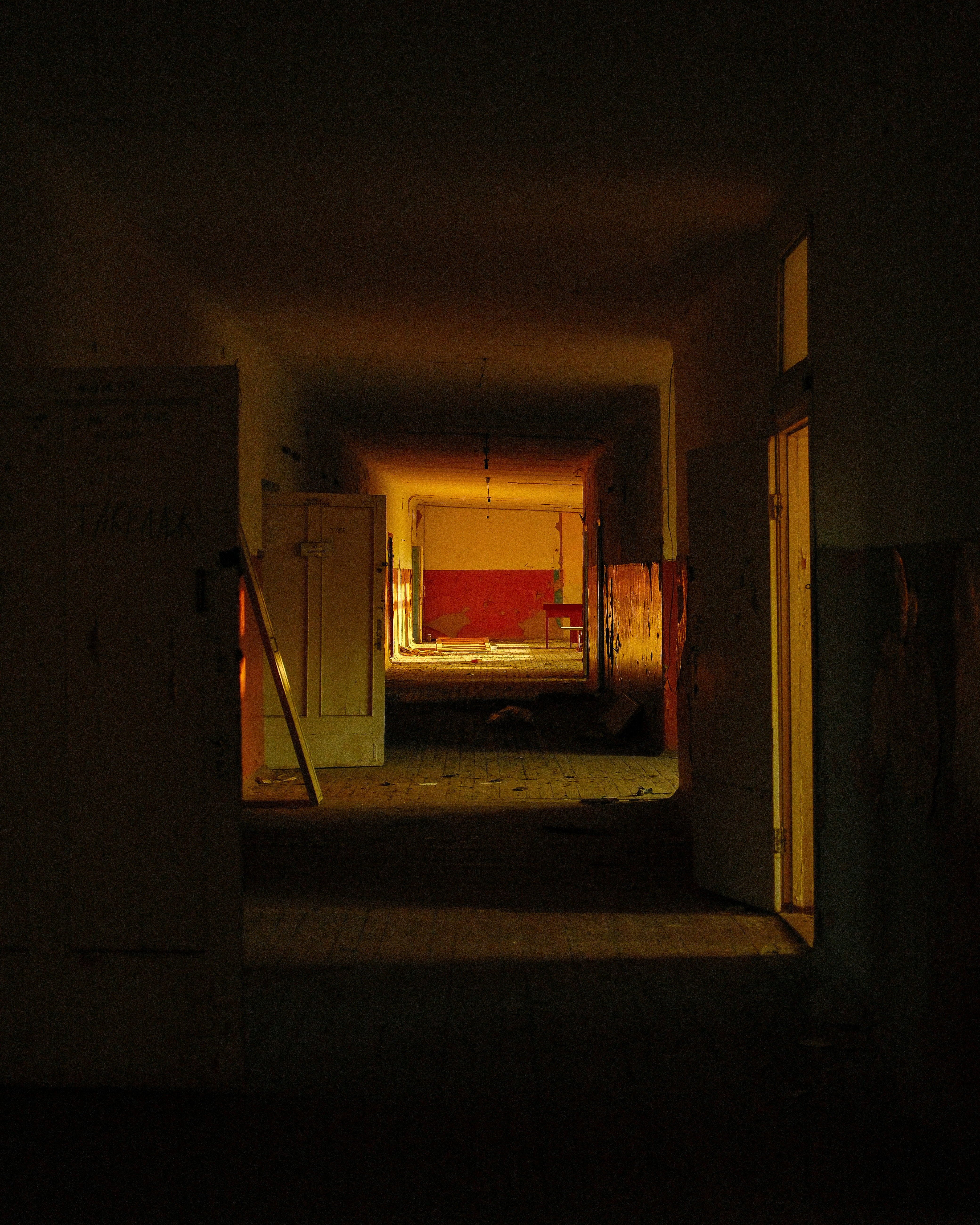 Dimly lit hallway with doorways on sides