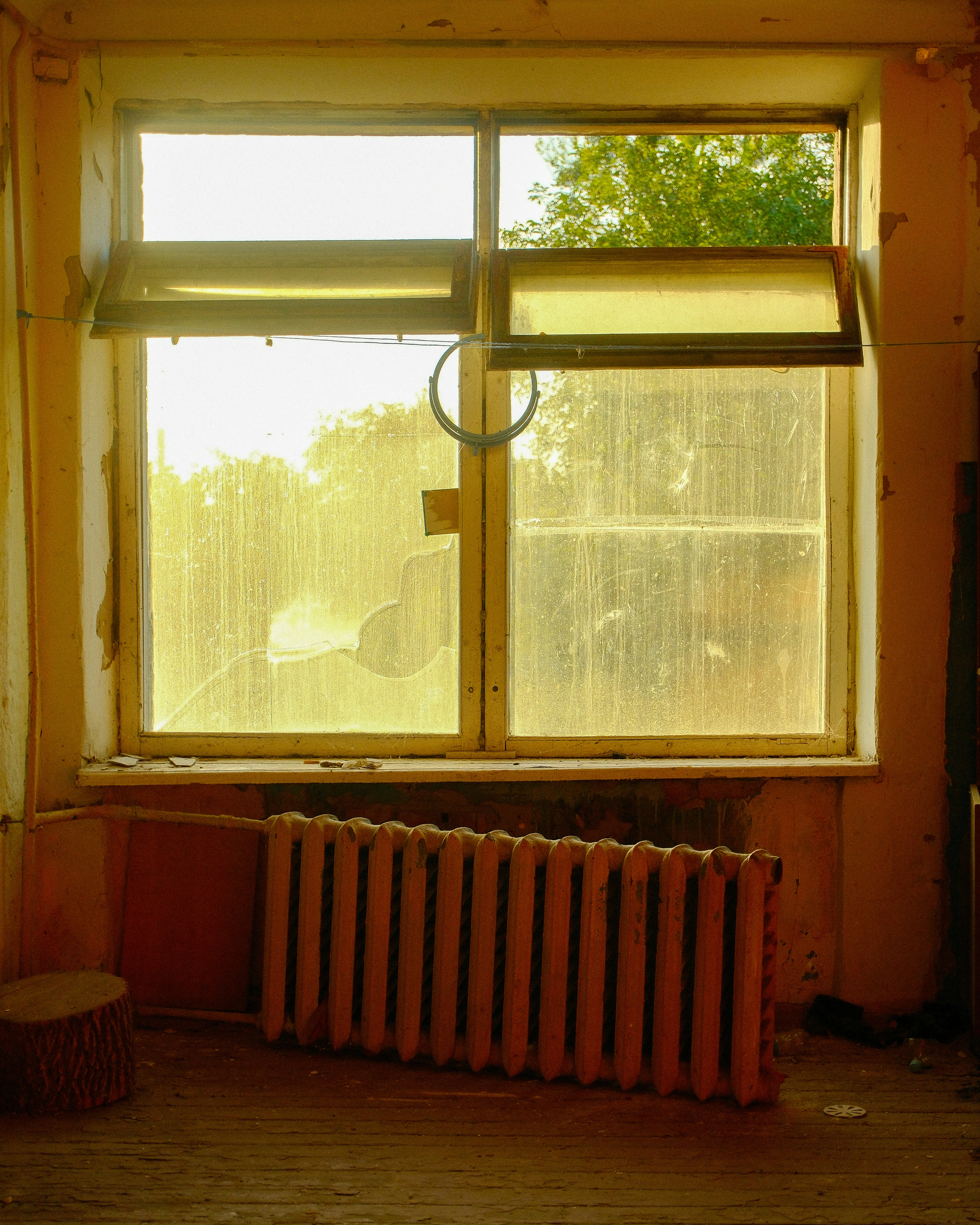 Old window with radiator and sunlight streaming in.
