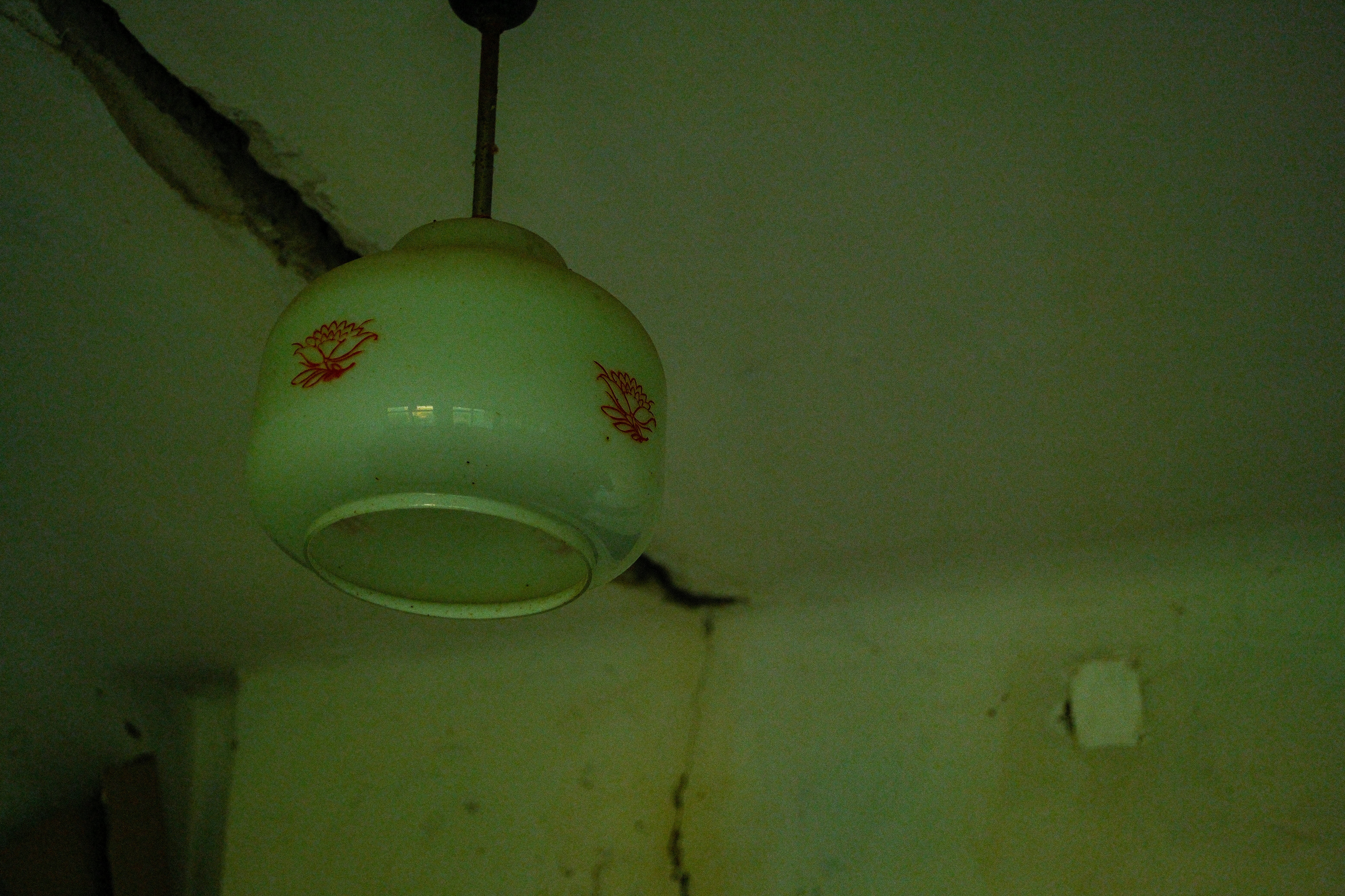Old ceiling light fixture with cracked walls