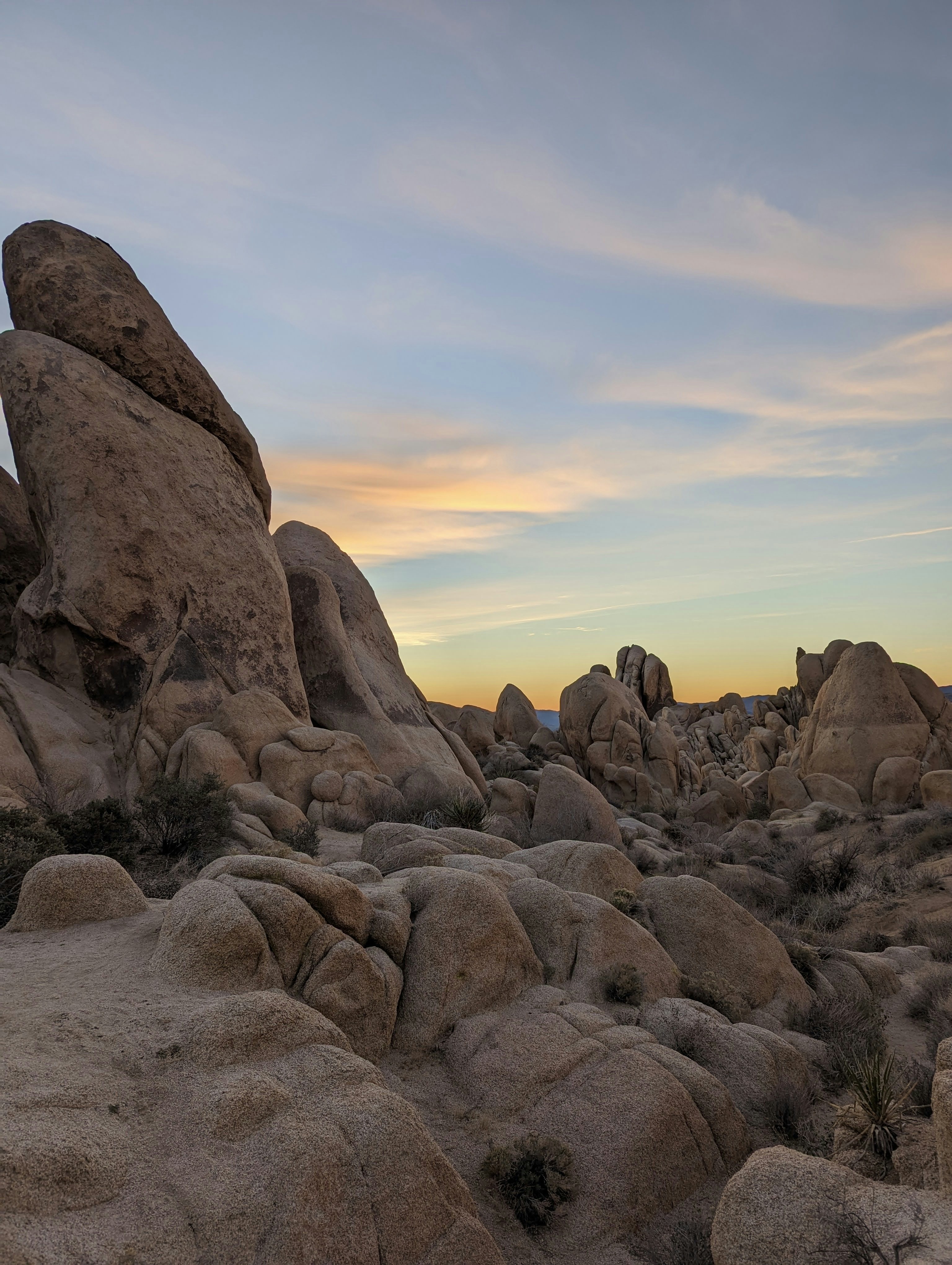 Unique rock formations bathed in the warm glow of sunset, showcasing the rugged beauty of the desert landscape.