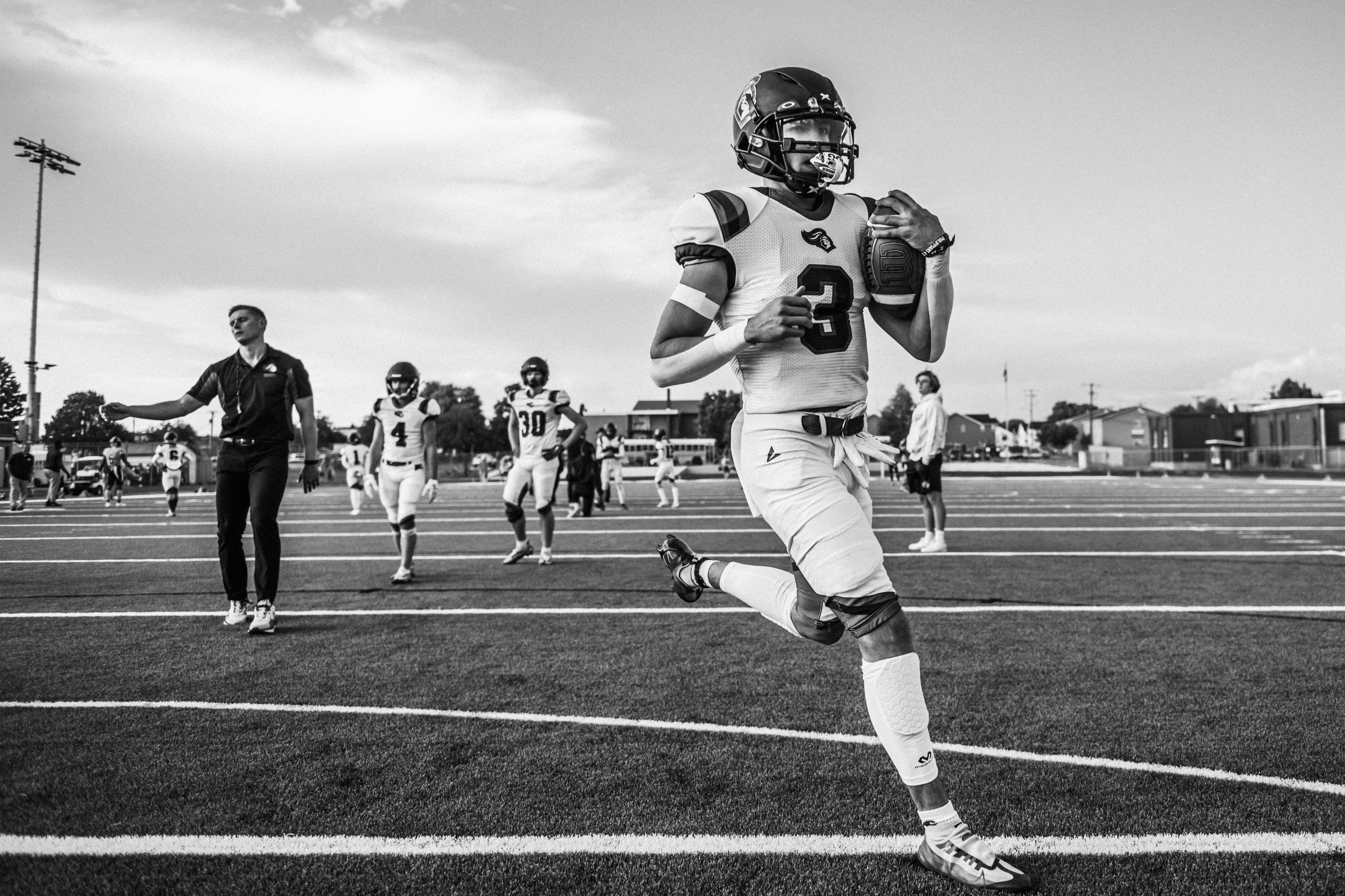 Pregame Practice | Football player running with ball on field