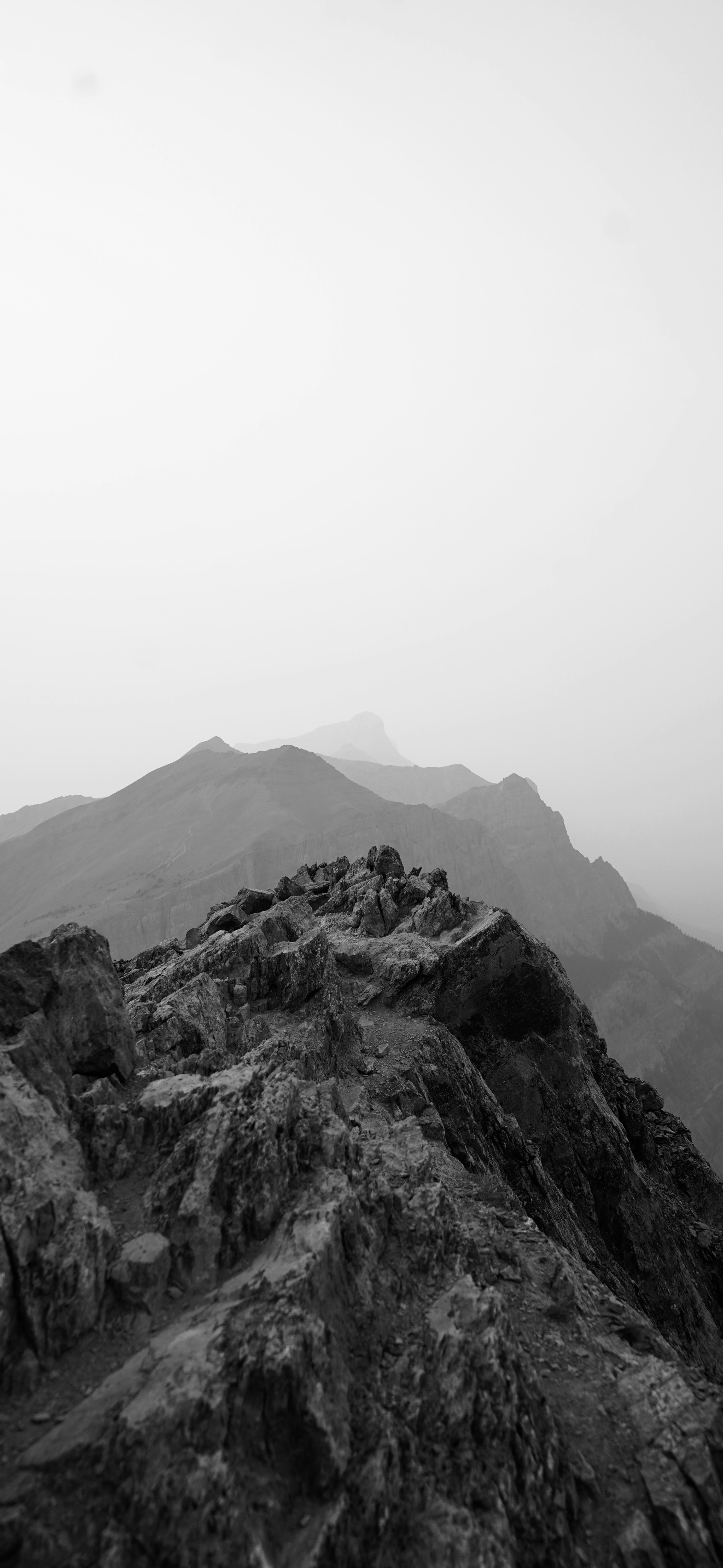 Rocky mountain ridge with misty peaks in background