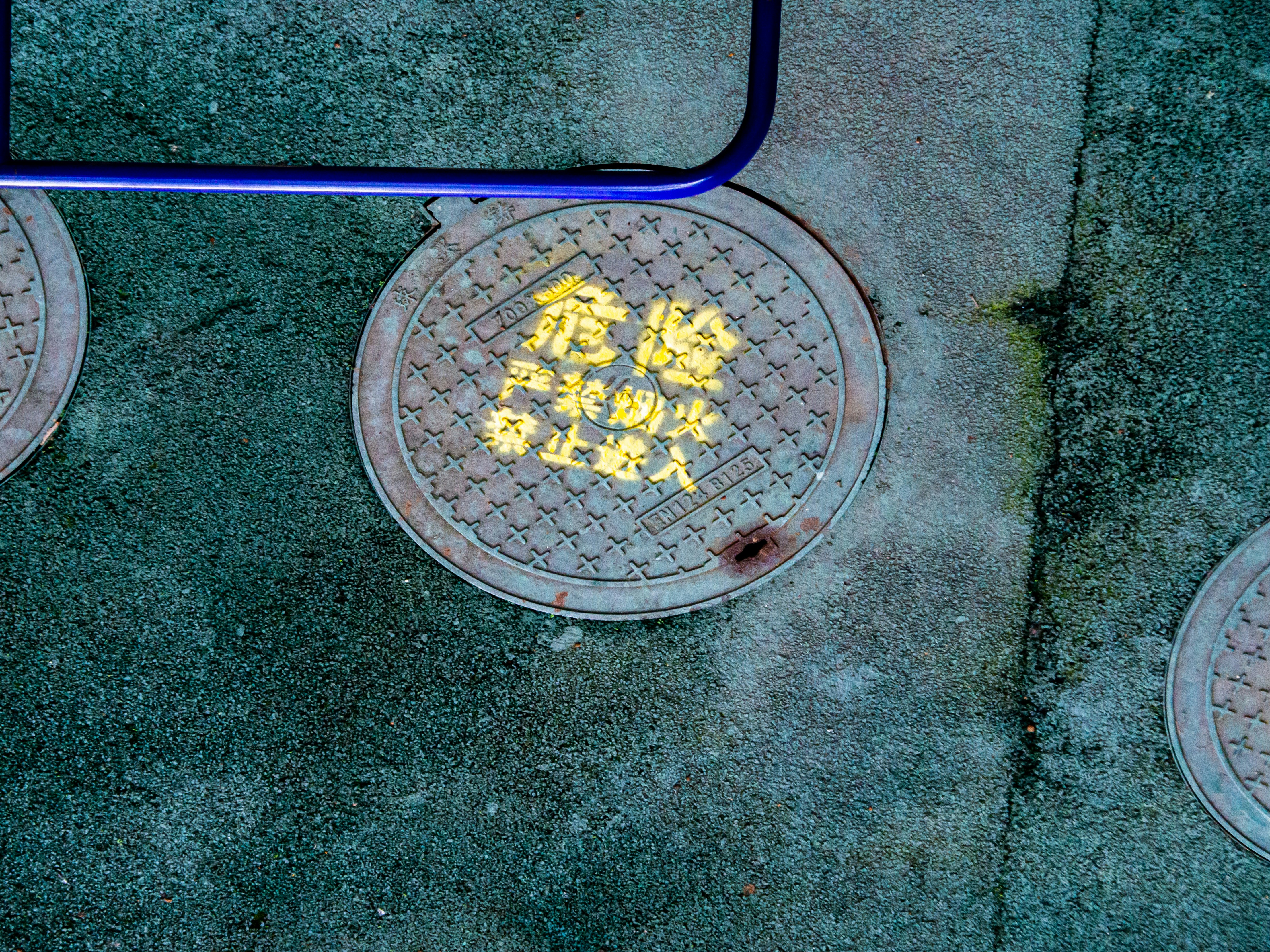 Round manhole cover with yellow warning text. photo – Free Texture ...
