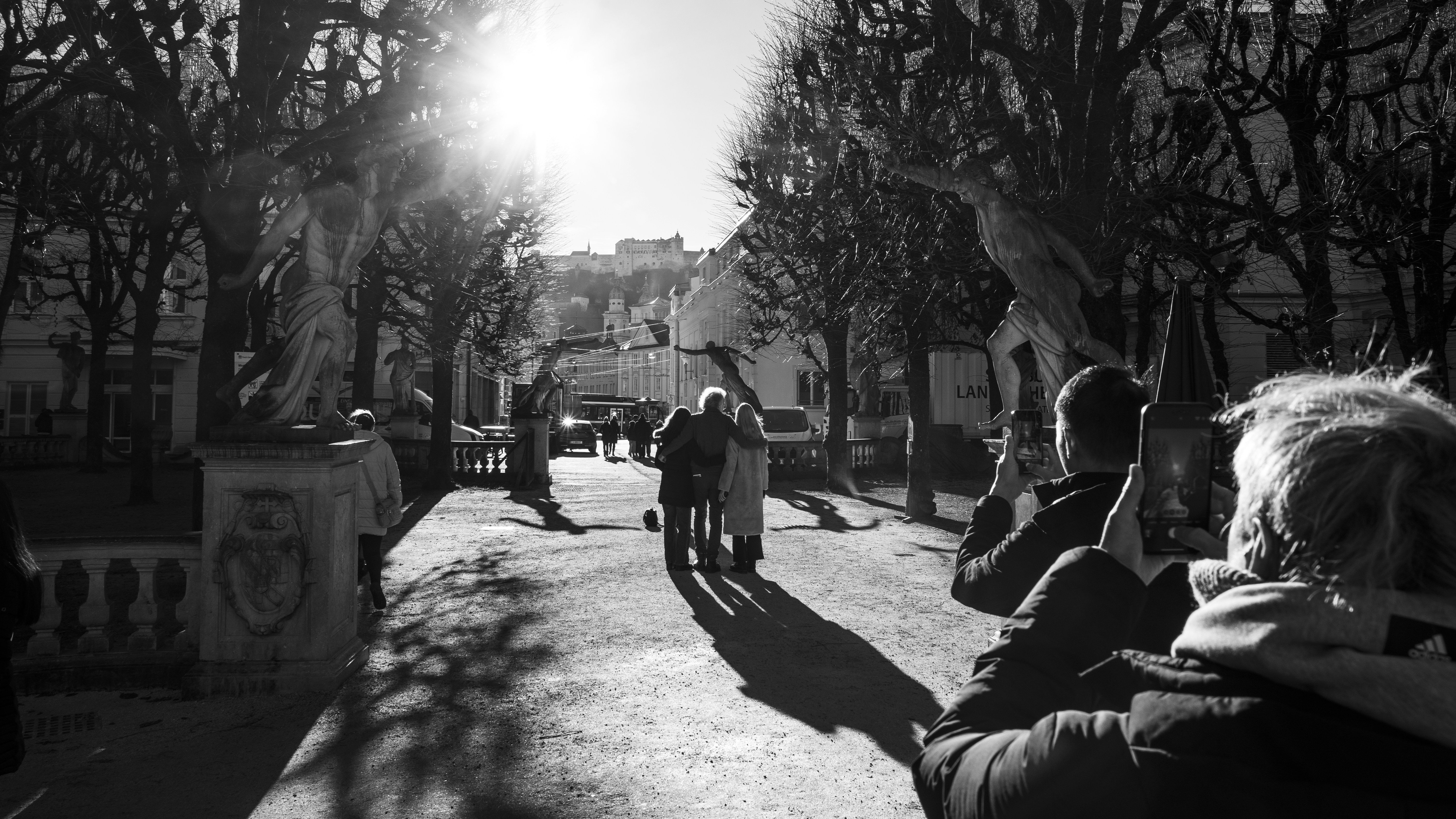 Silhouettes and Long Shadows on a Statues-Lined Promenade