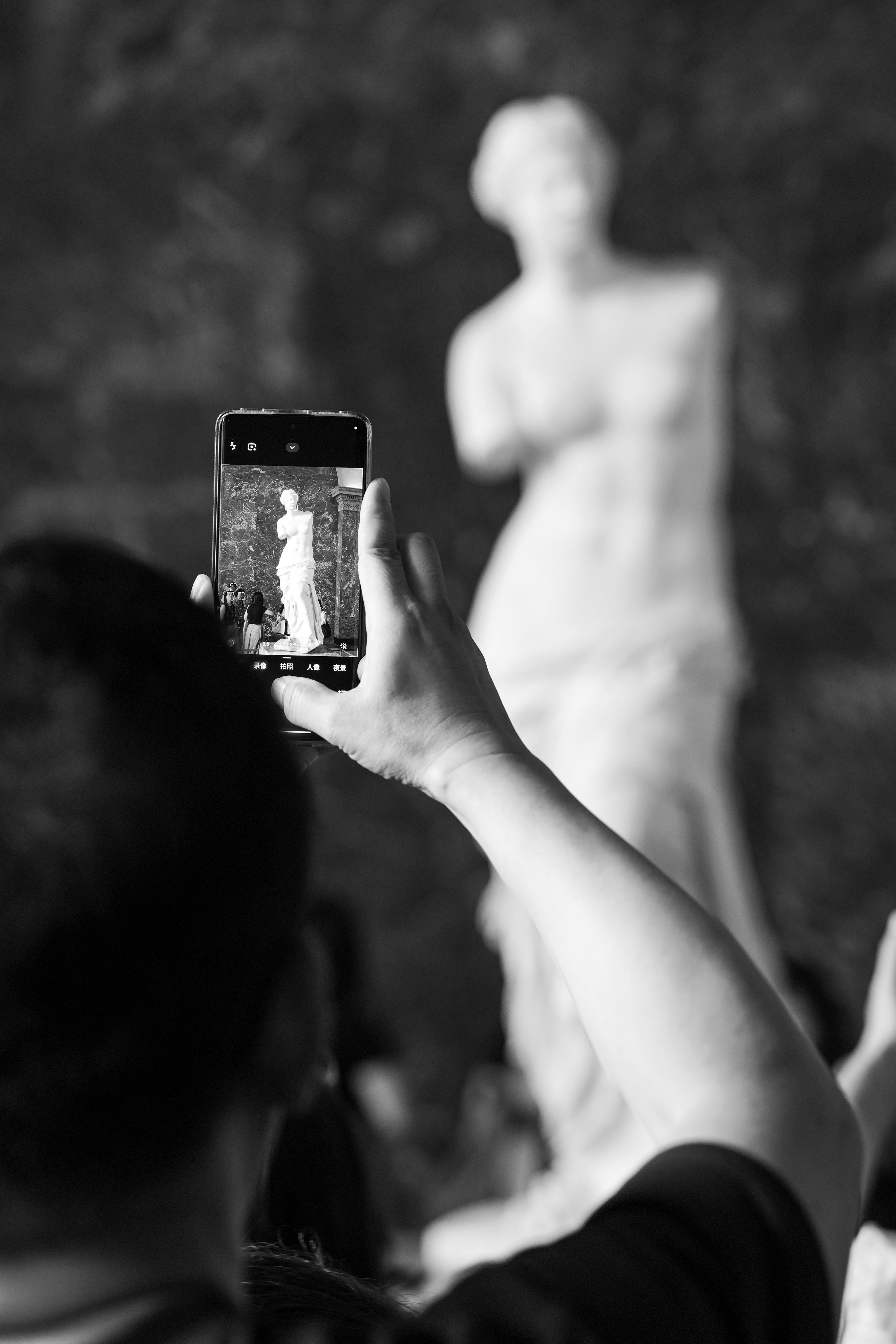 Nicht die Kunst wird betrachtet, nur durch das Smartphone wird wahrgenommen was eigentlich zu betrachten wäre | Person taking a picture of a statue with a smartphone.