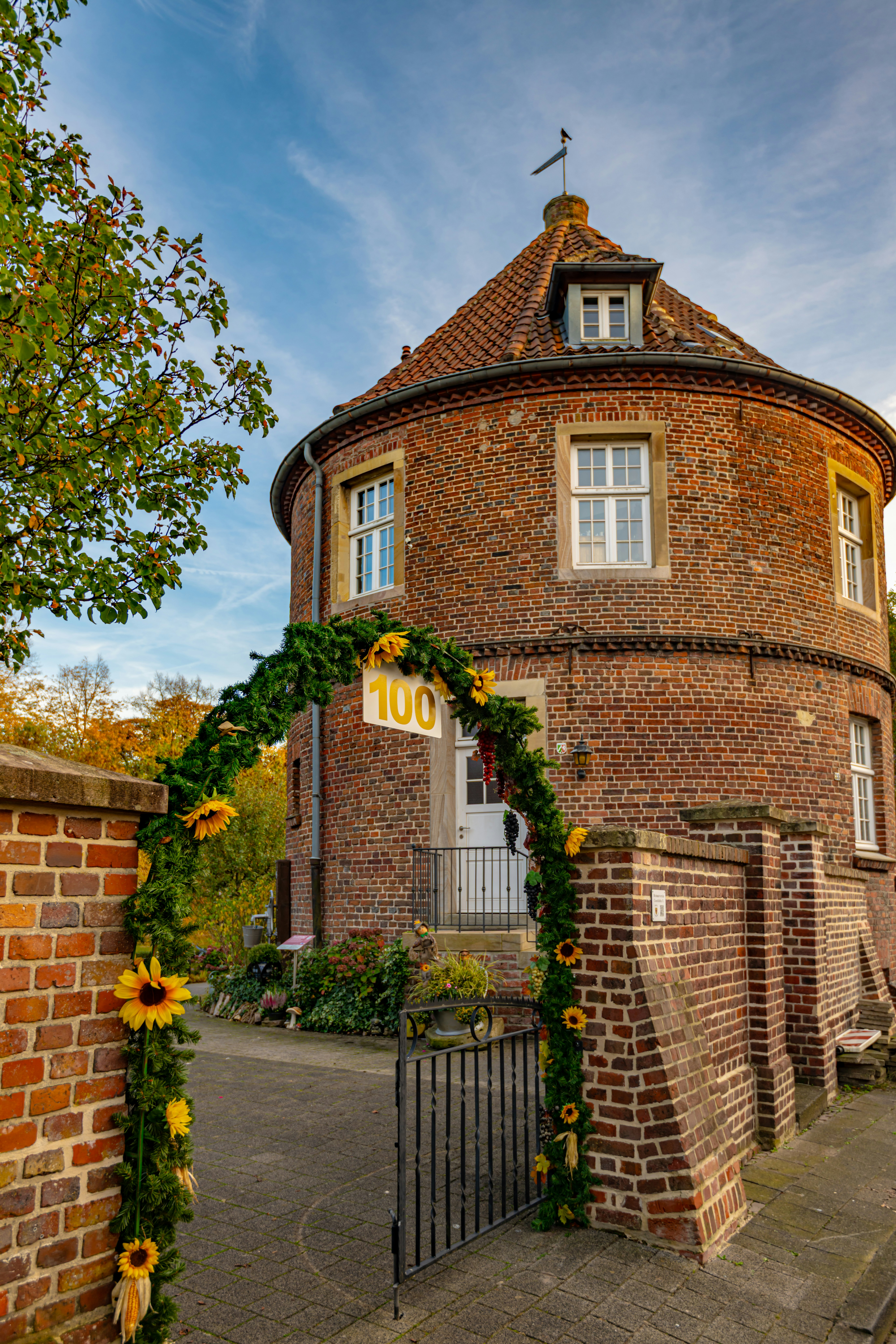 Round brick building with festive archway and sunflowers