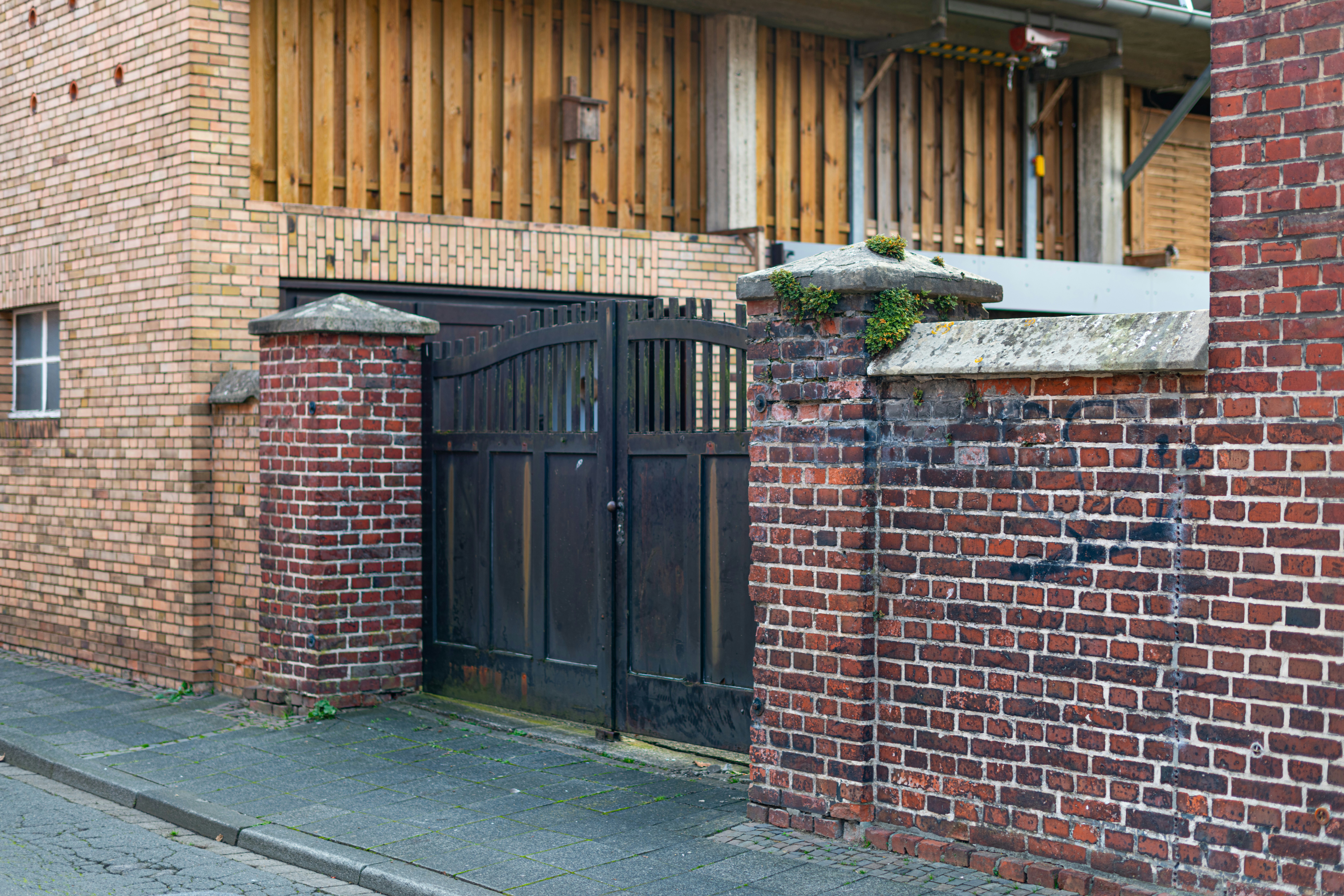 A wooden gate set in a brick wall