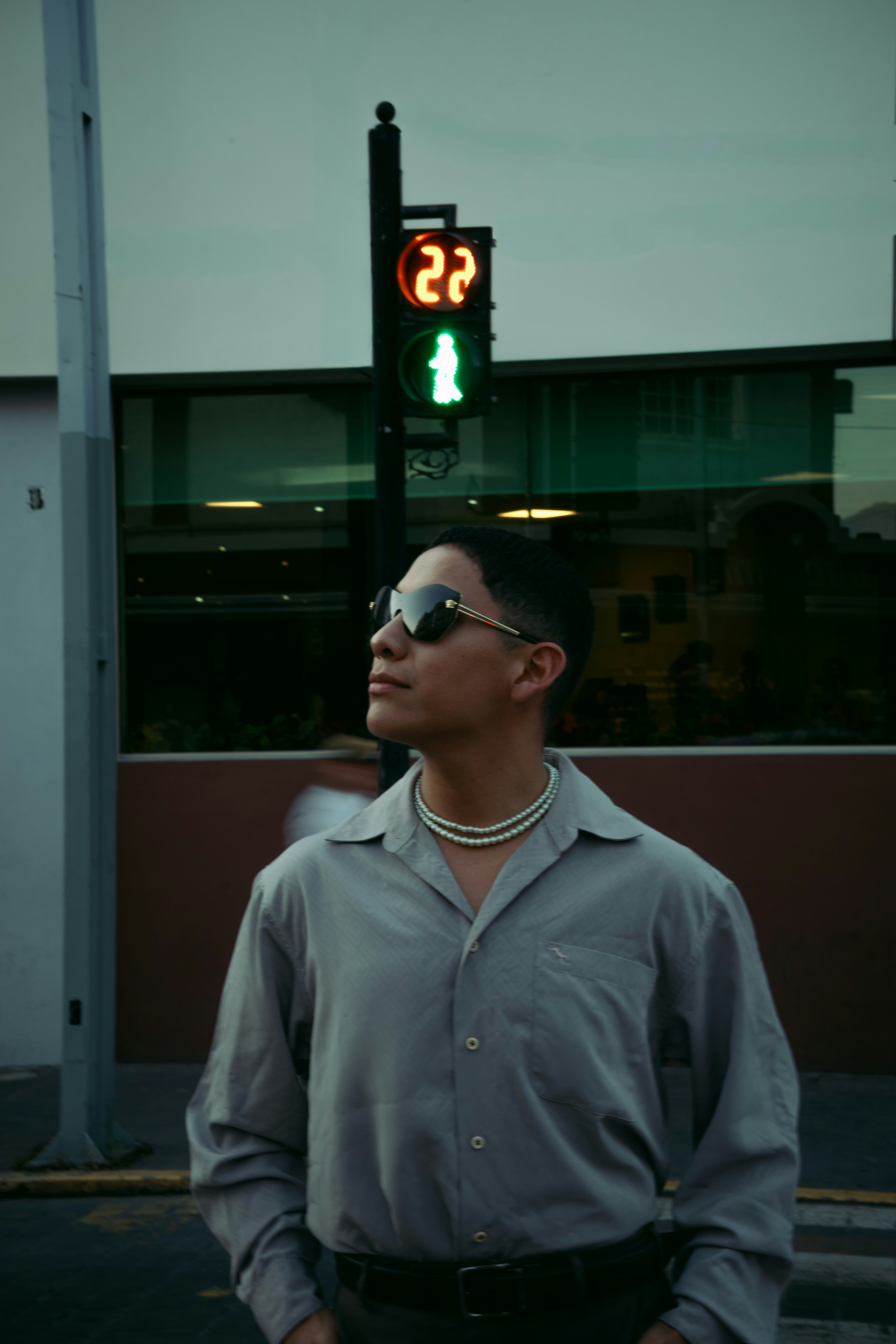 Man wearing sunglasses near a traffic light
