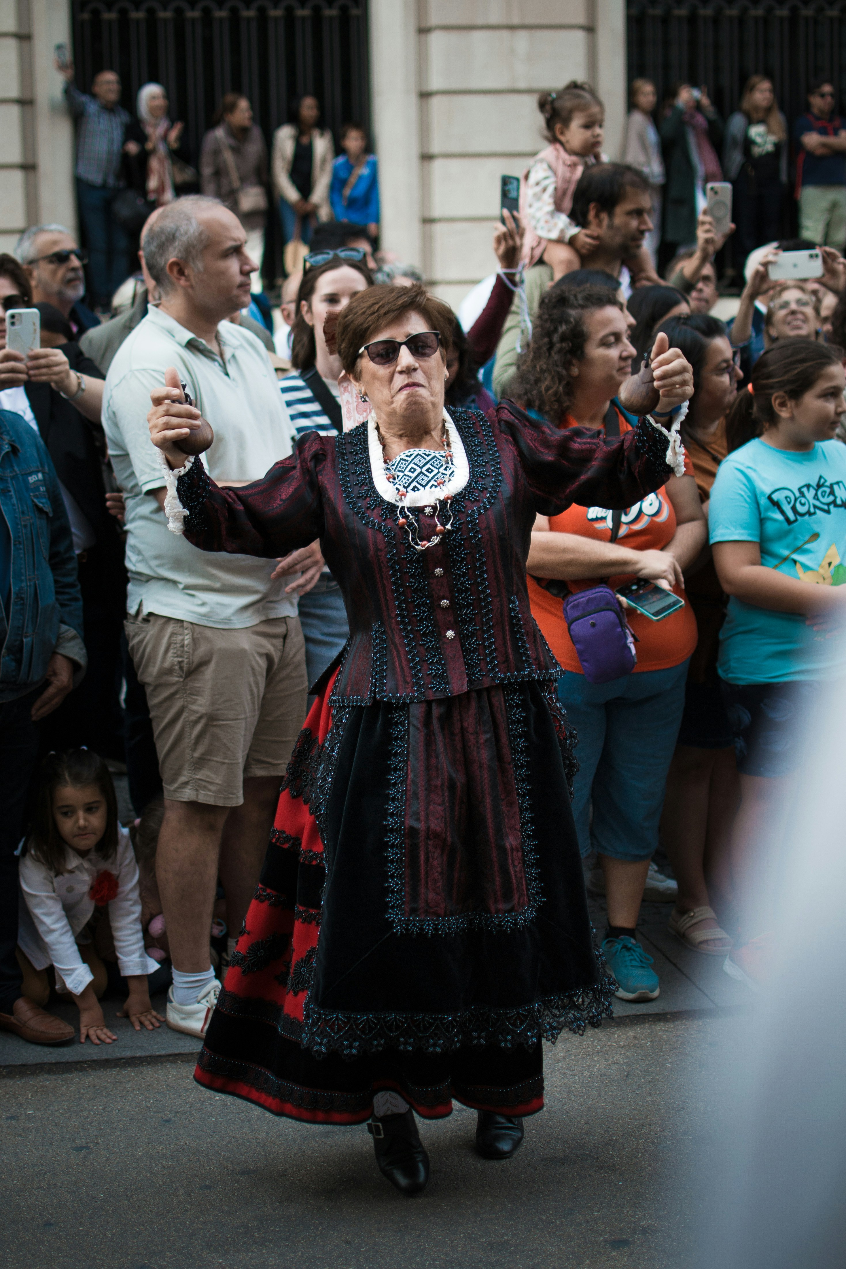 Woman in traditional dress dancing in a street festival.