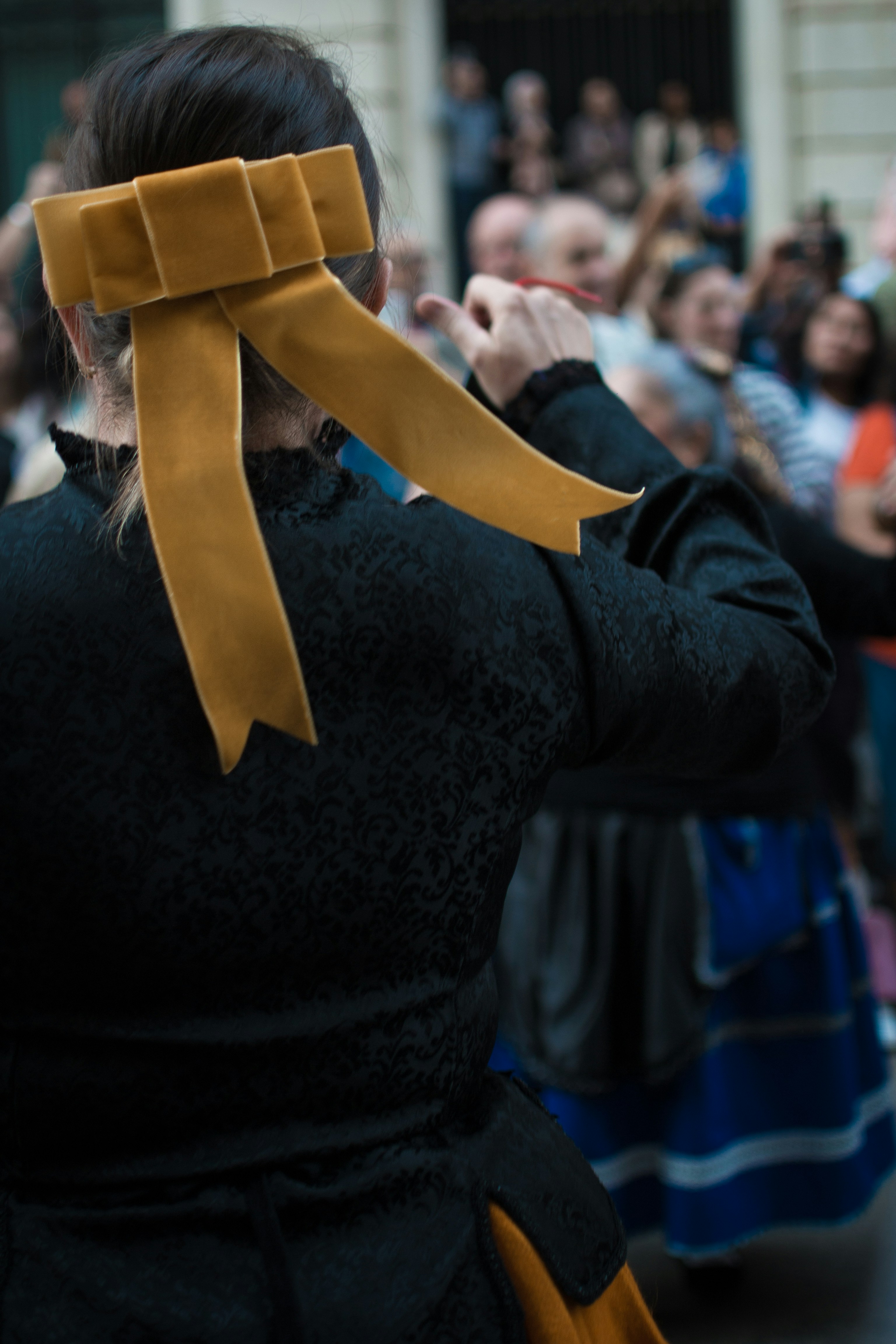 Woman with large golden bow in her hair dancing