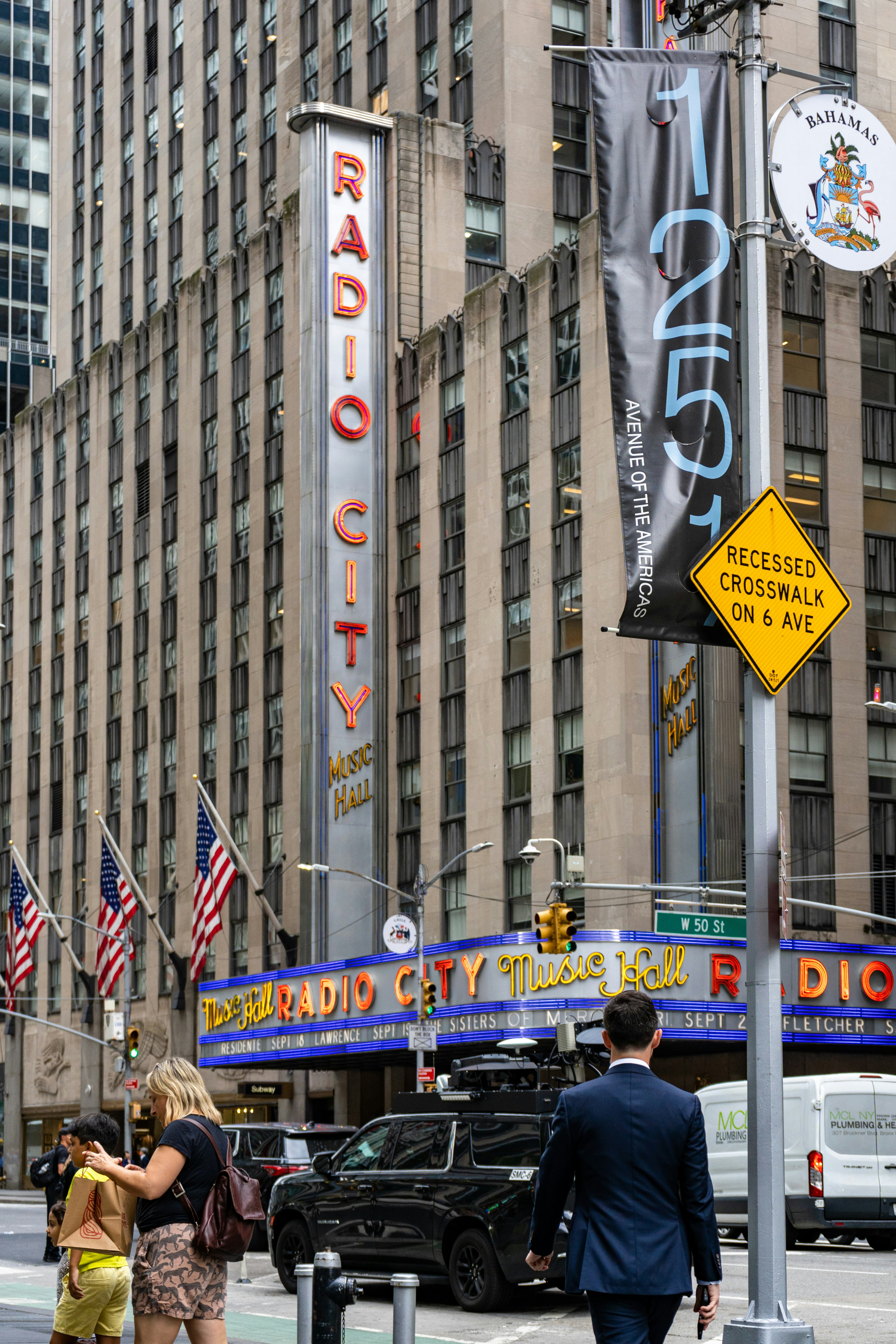 Radio City Neon and Street Pulse: People, Signage, and Traffic on a Bustling Avenue