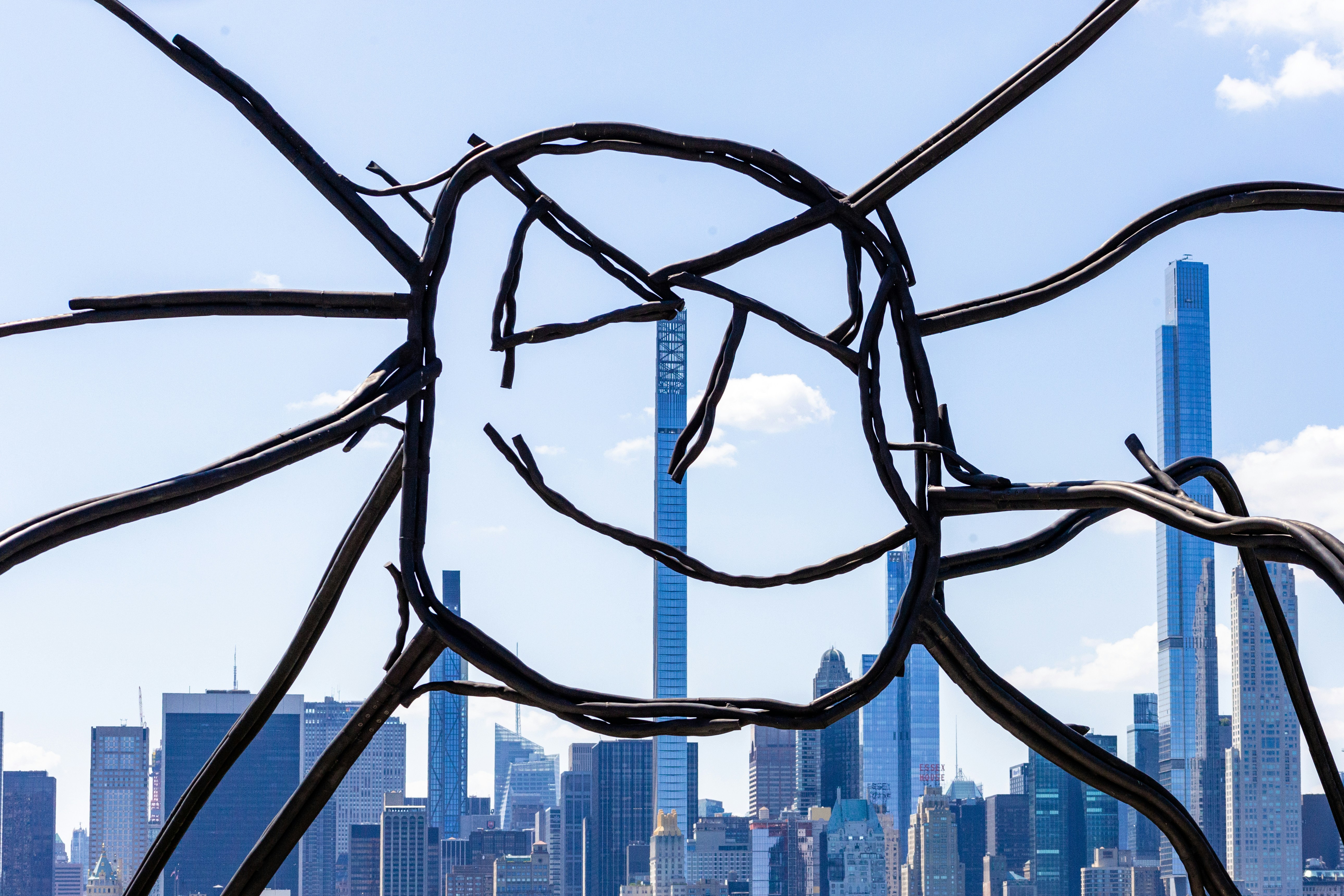 Abstract sculpture intertwining with a city skyline, juxtaposing organic shapes against modern architecture.