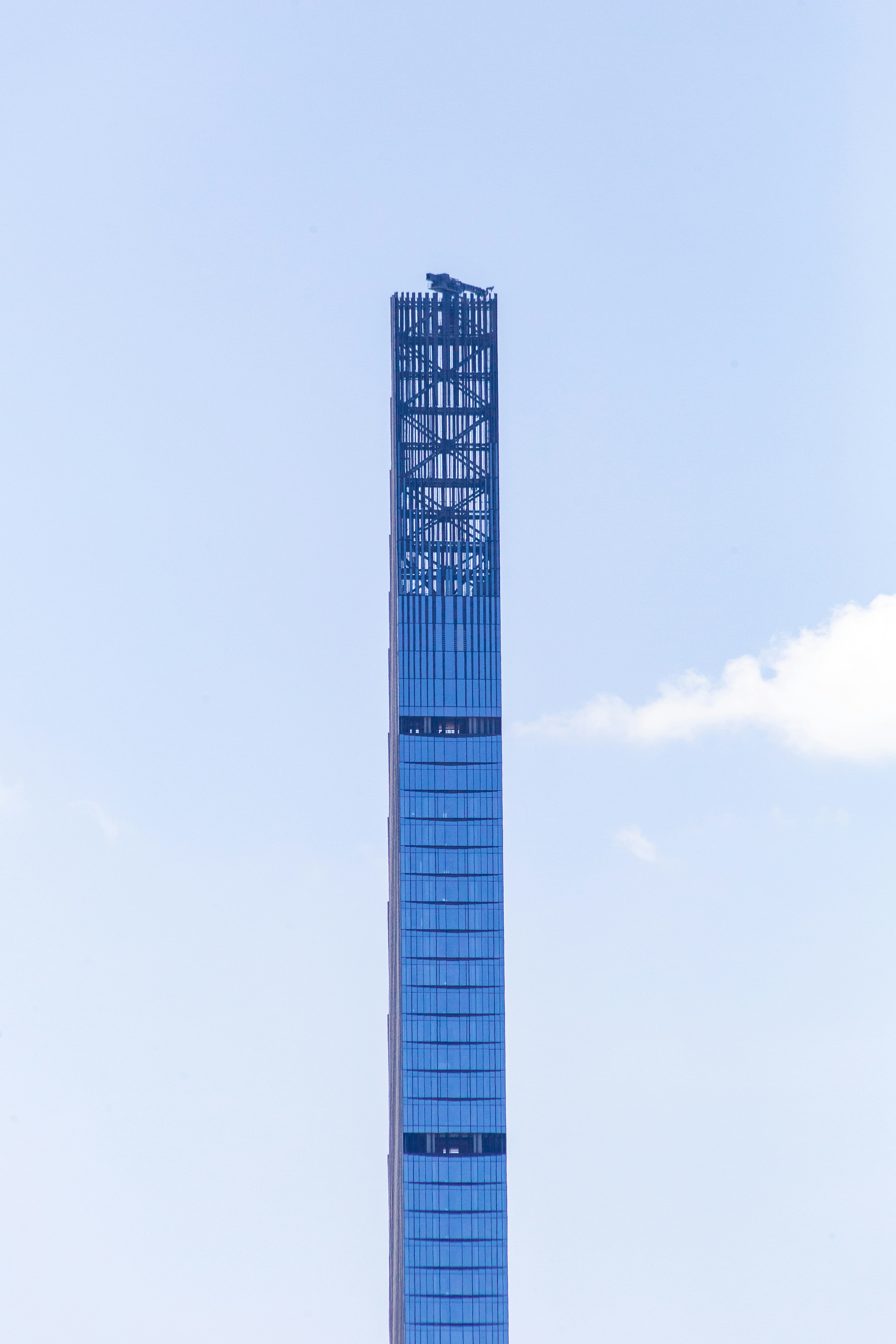 Modern skyscraper with blue glass facade against sky
