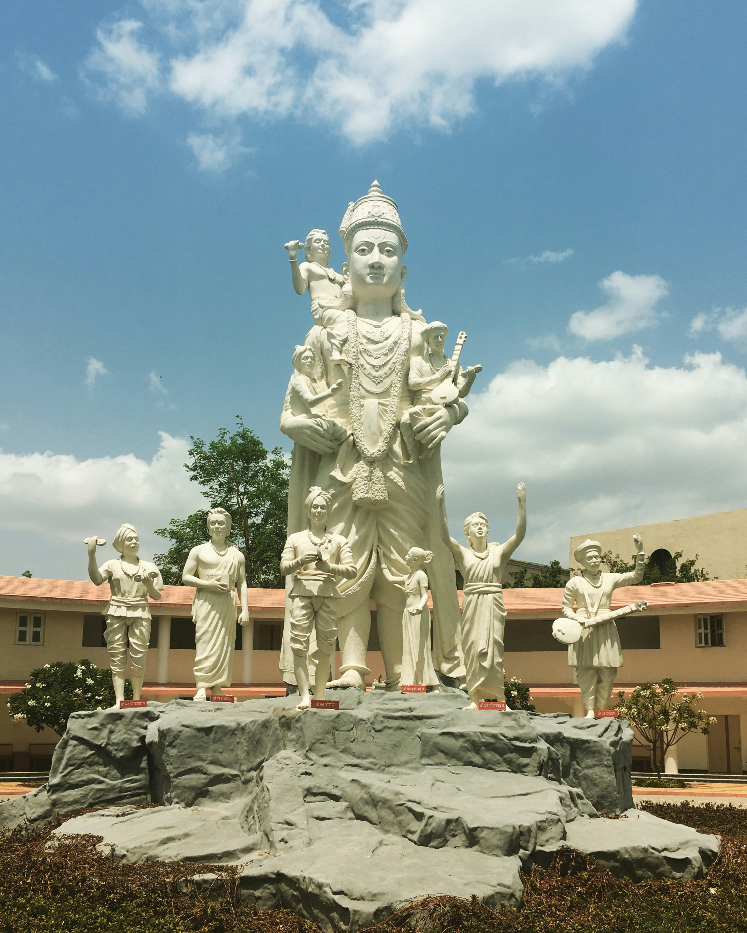 Large white statue of a deity with children.