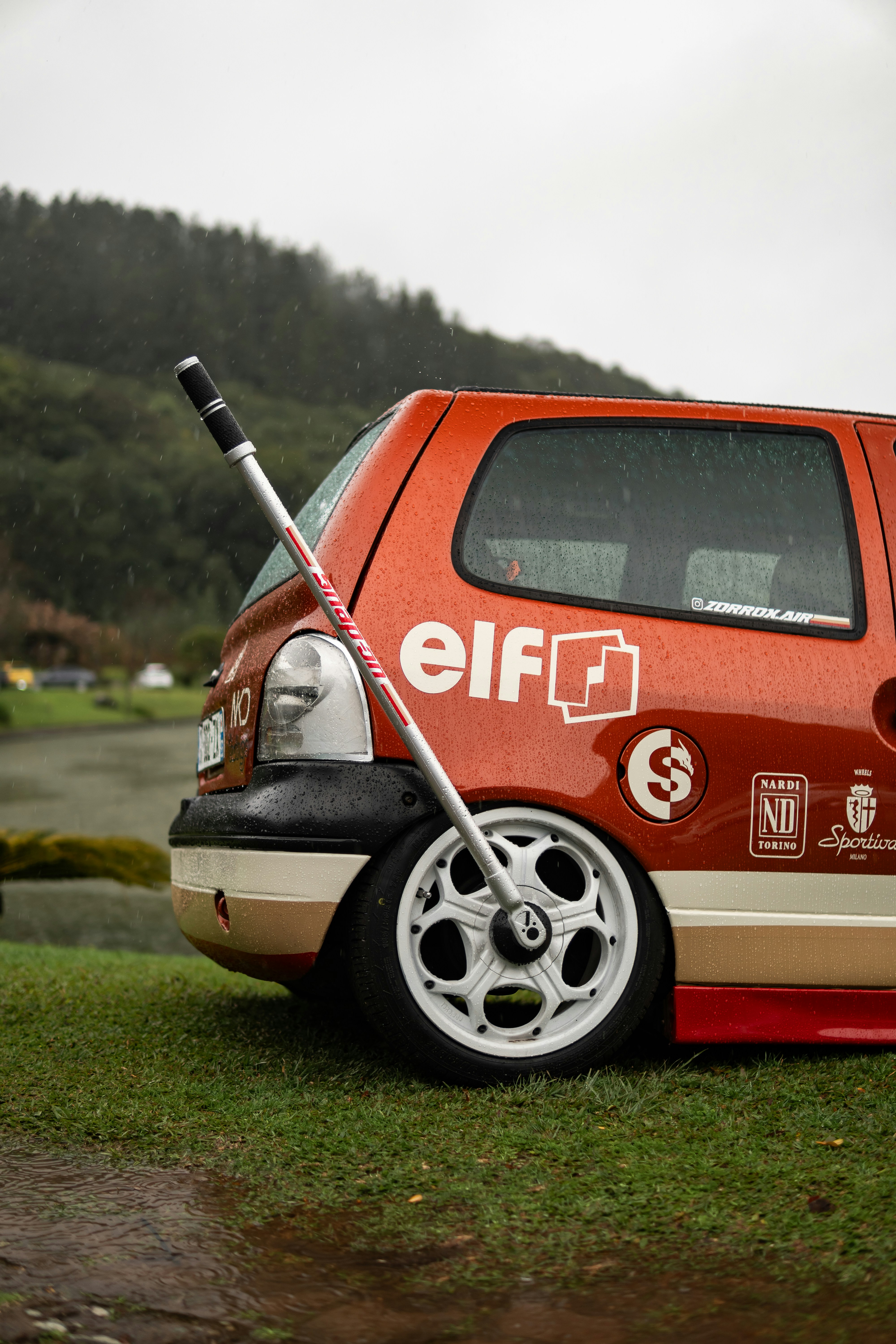 Red Rally Robe: A Close-Up of a Stance-leaning Mini in Rain