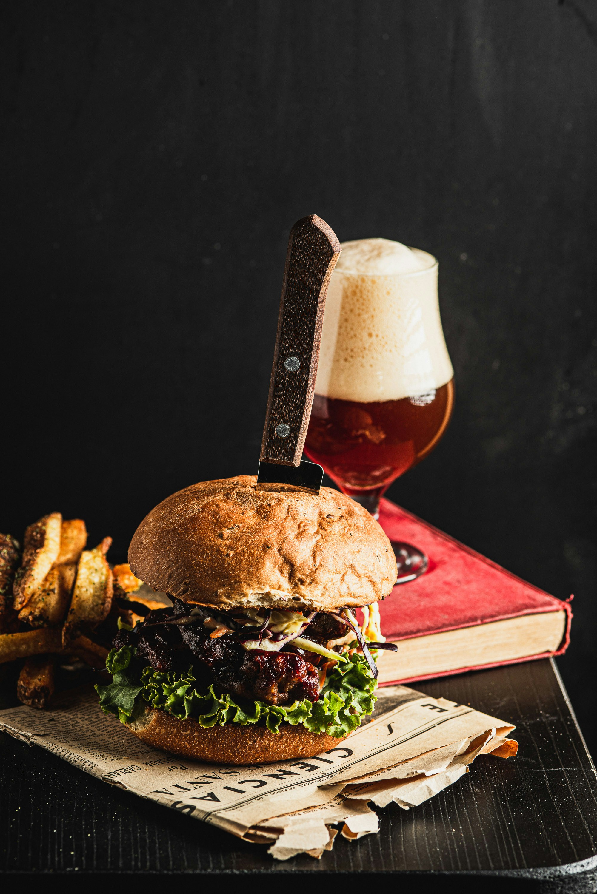 Juicy burger with fries and a glass of beer.
