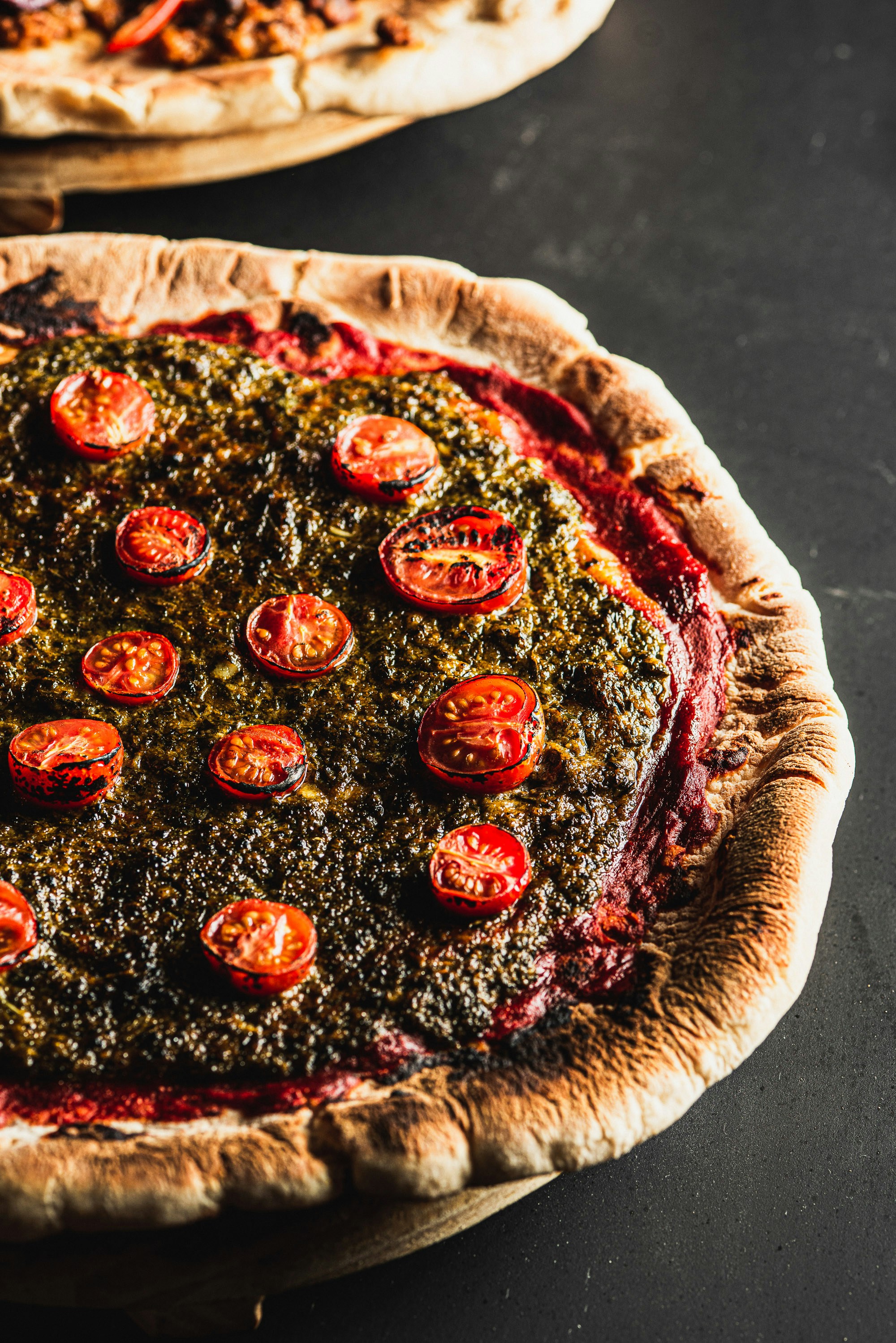 Crust and Crimson Orbs: A Rustic Tomato-Pesto Pizza Close-Up