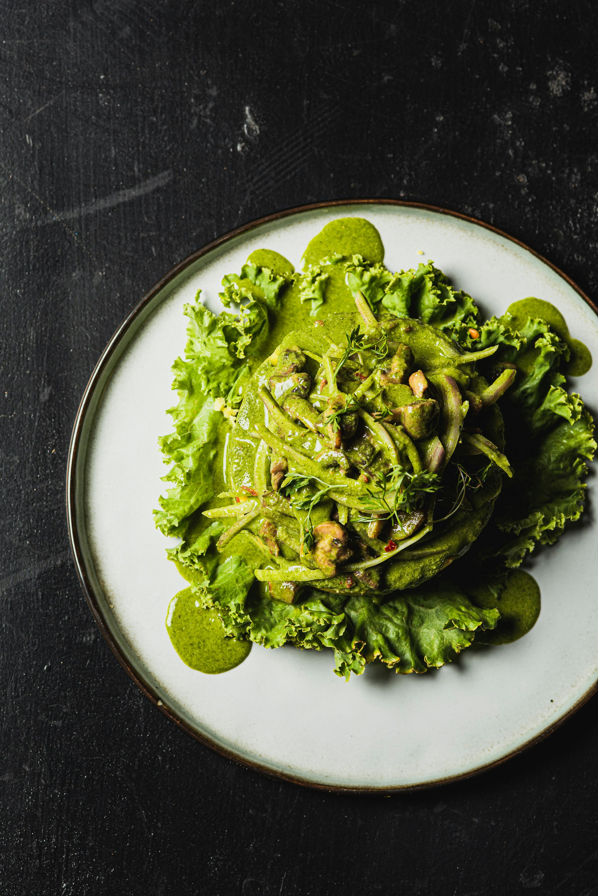 Green salad with dressing on a white plate
