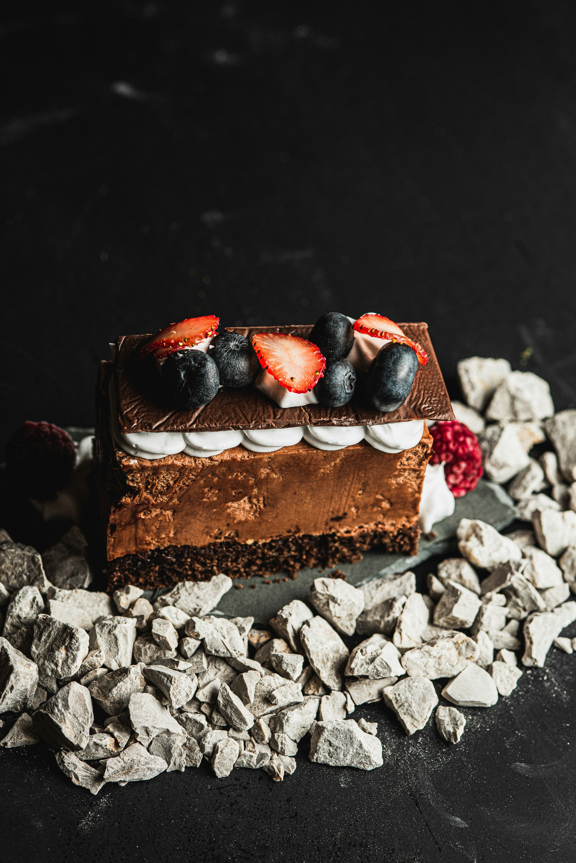 Berry-Crowned Chocolate Layer Cake on a Pebble Bed